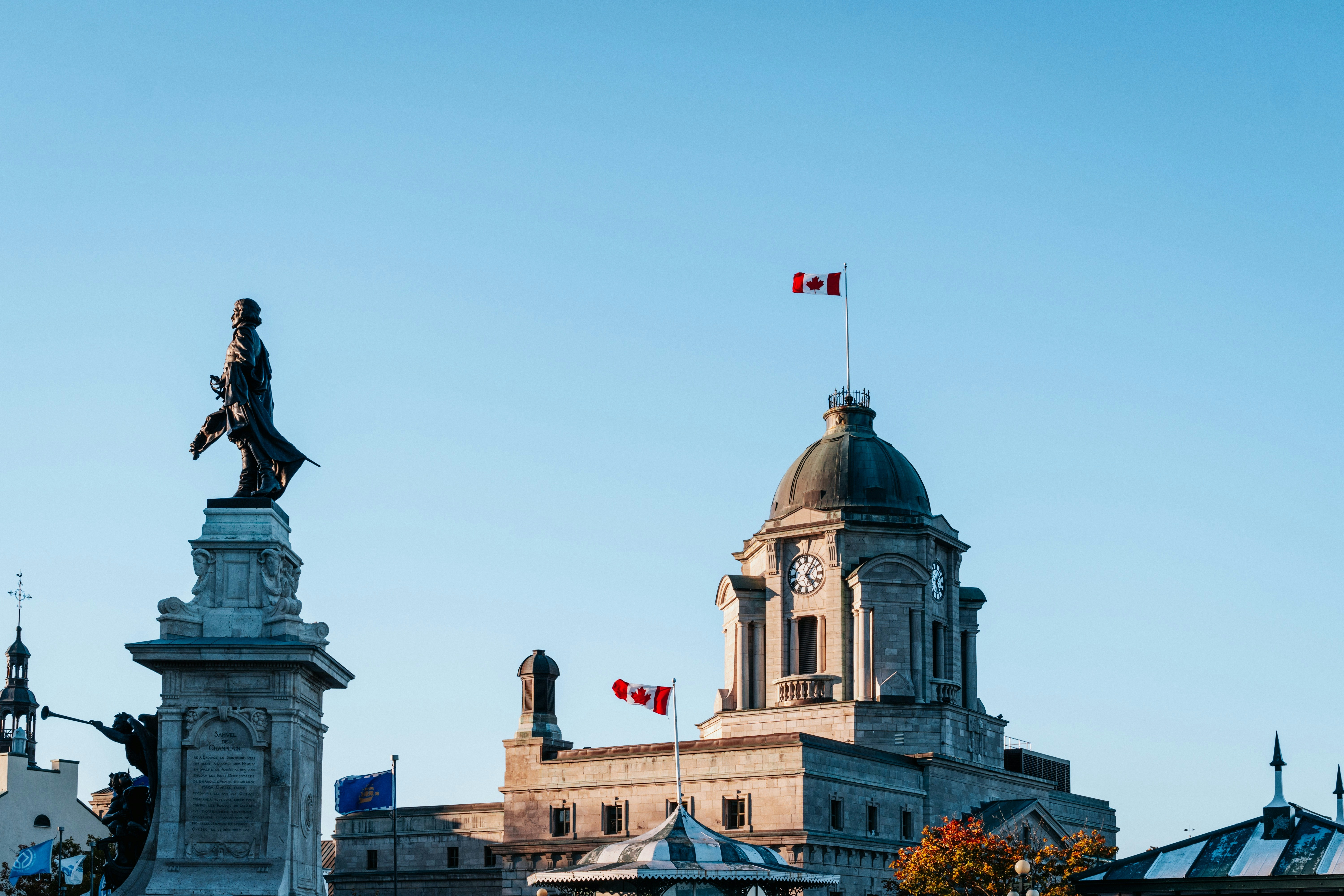 Historic building with statue and canadian flags