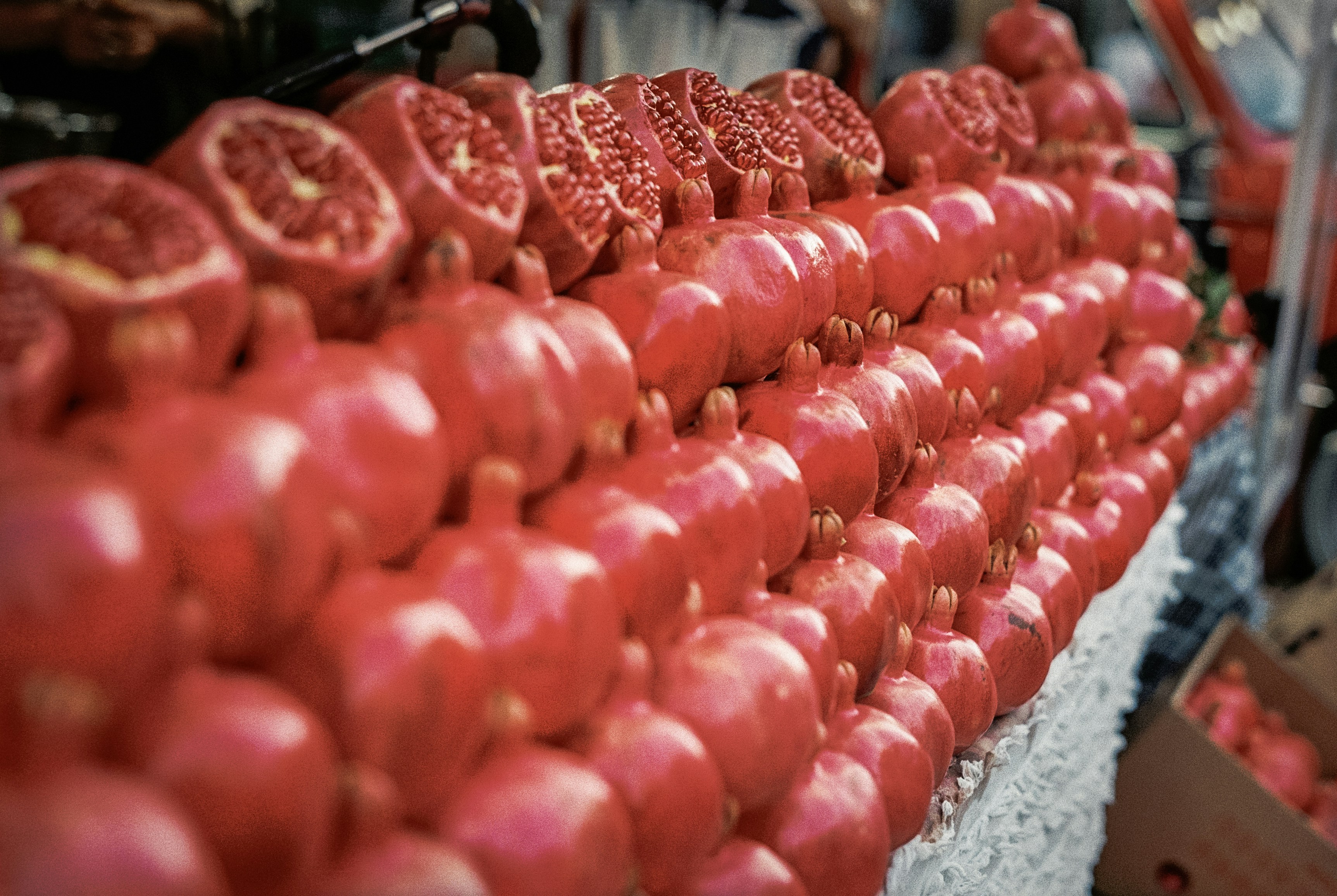 Vibrant display of pomegranates stacked neatly at a market, showcasing their rich color and texture.
