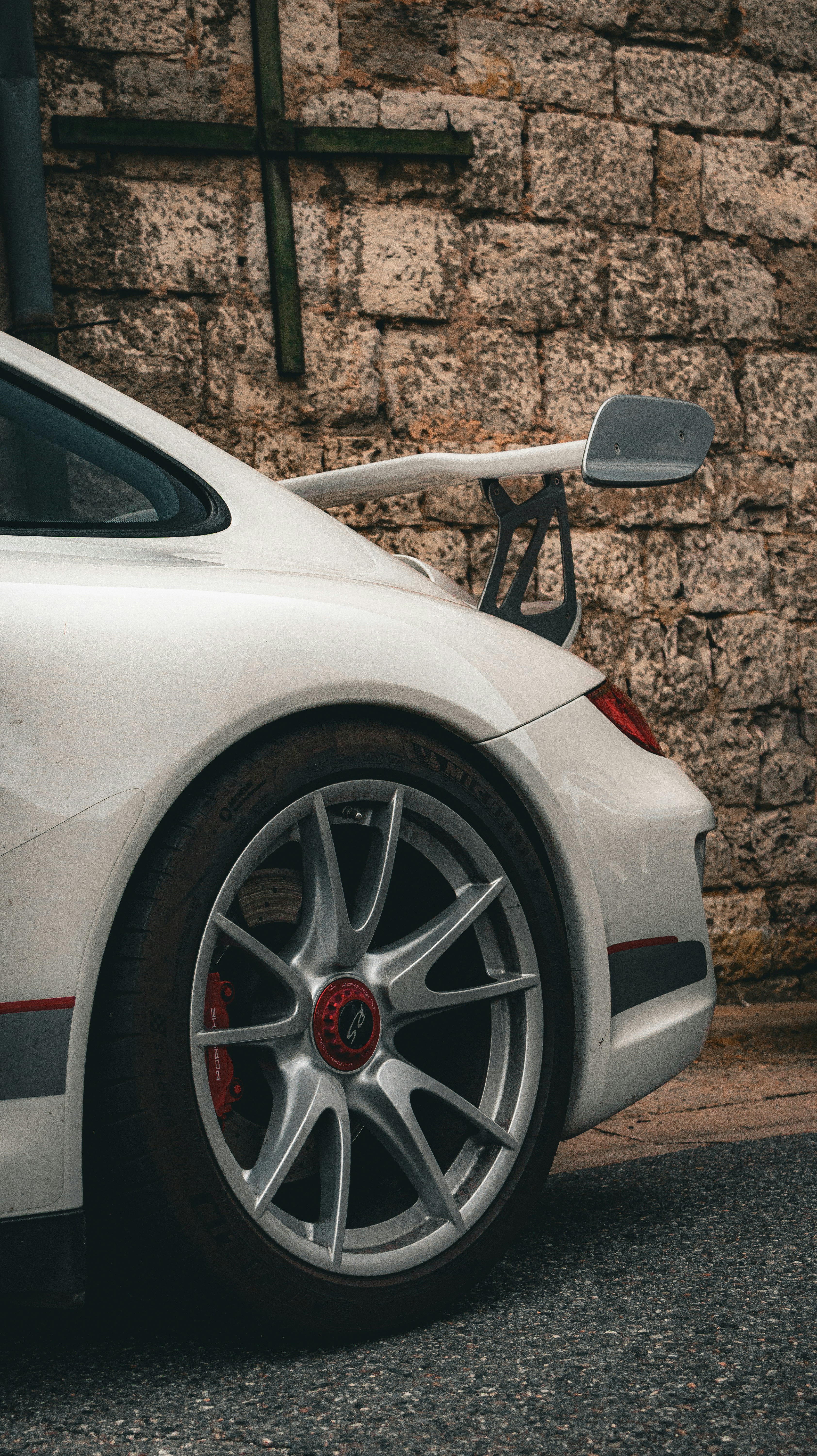 White sports car with a large spoiler parked outdoors.