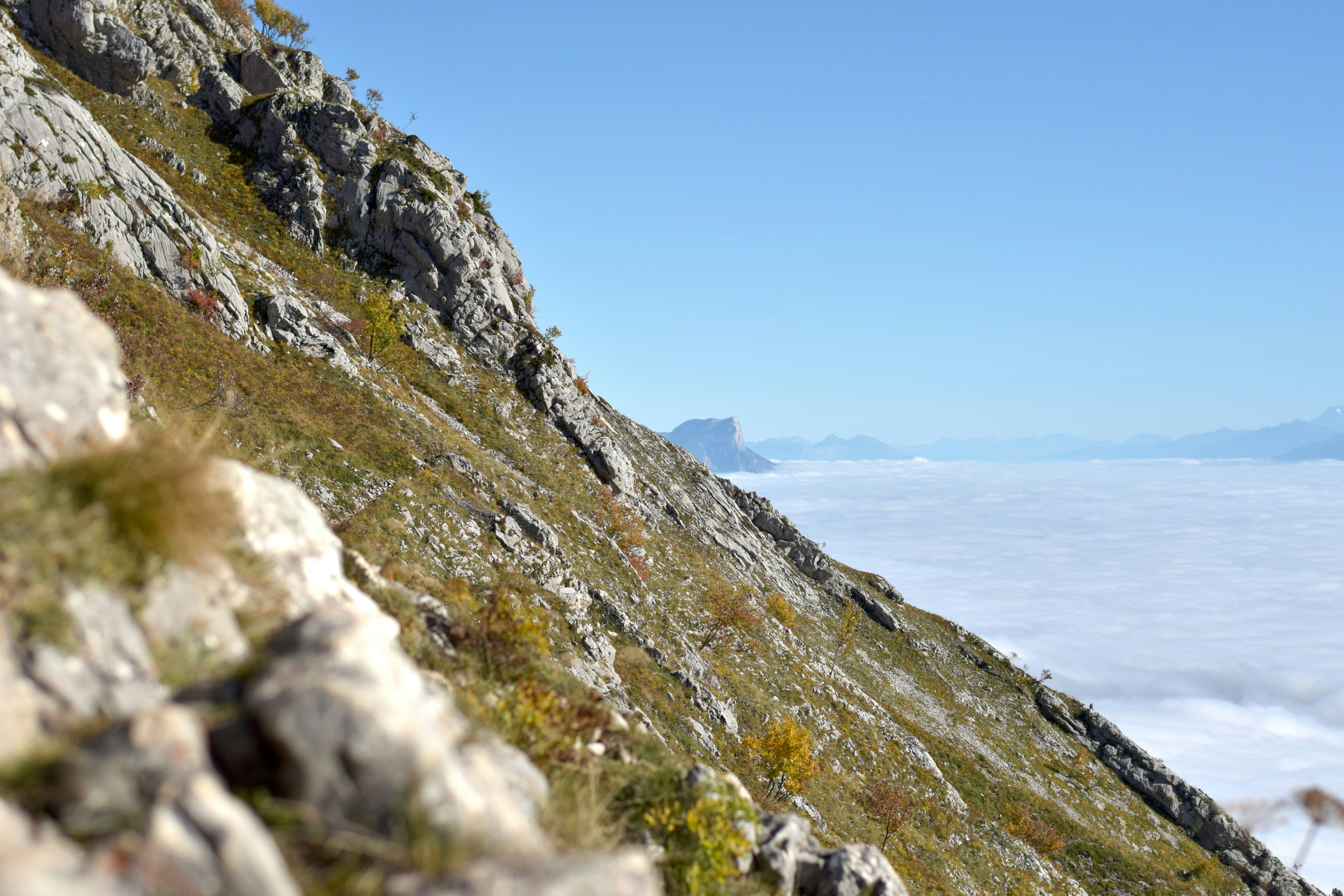 Rocky mountain slope above a sea of clouds