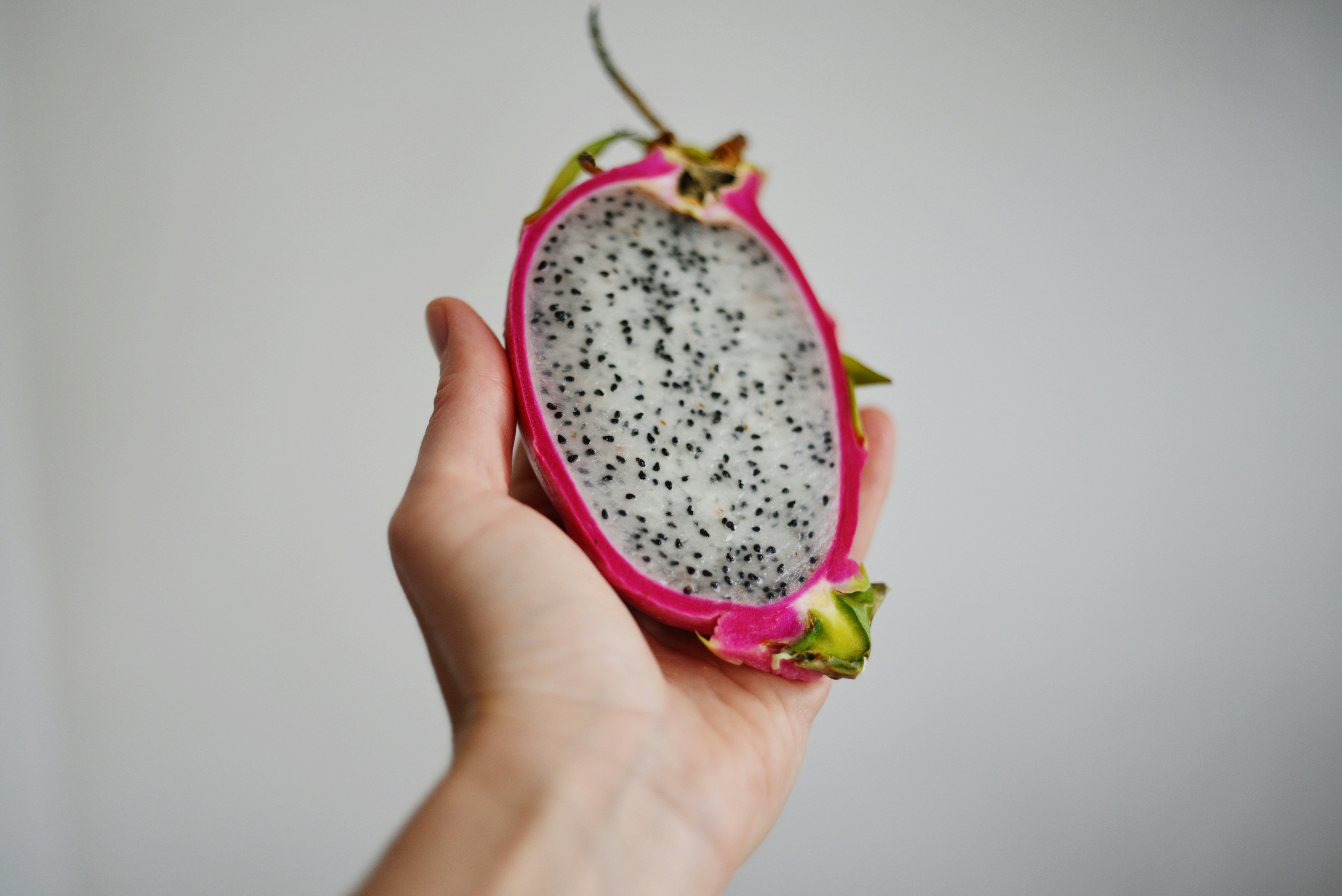 Hand holding a halved dragon fruit