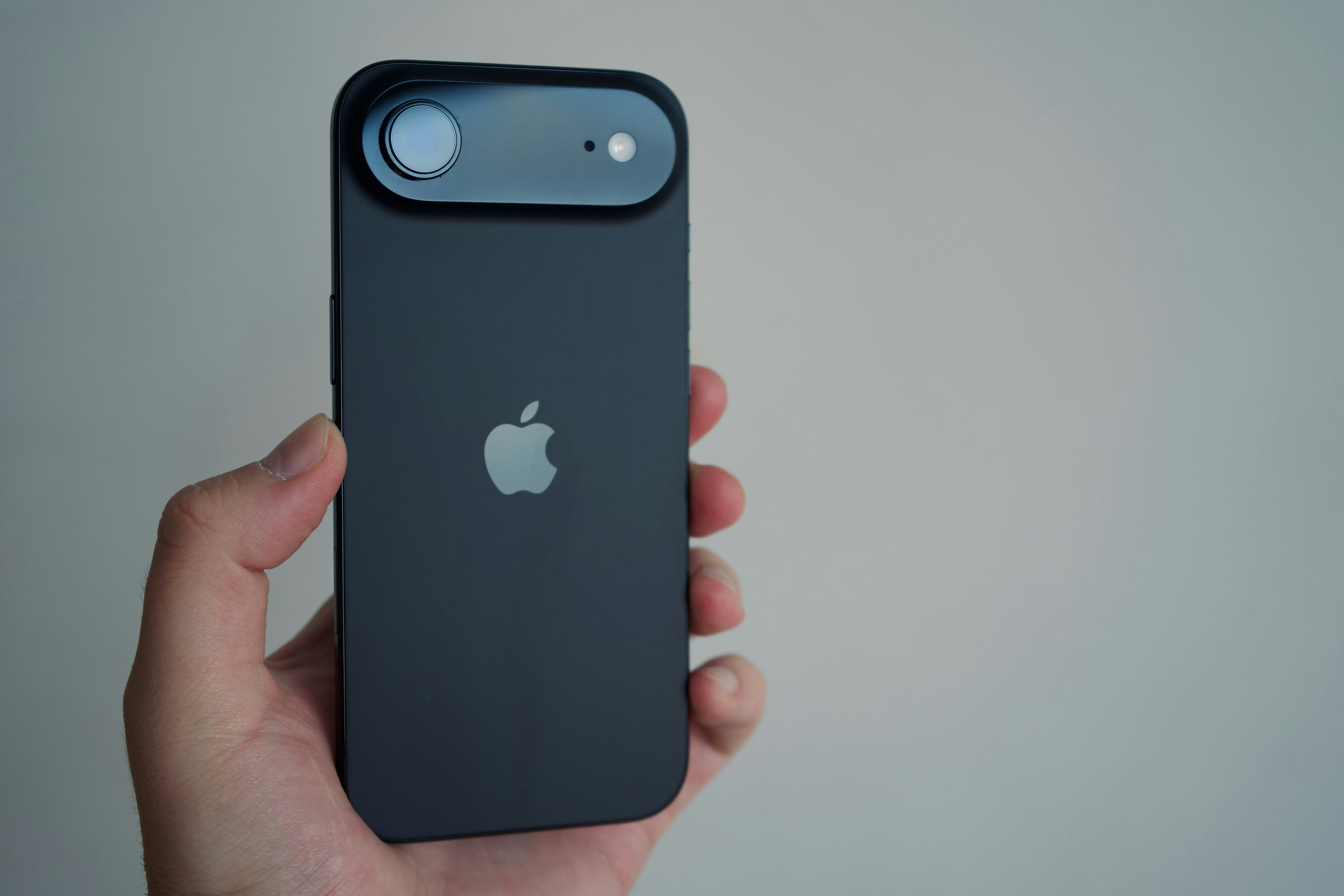 Apple iPhone Air in black | Hand holding a dark smartphone with apple logo.