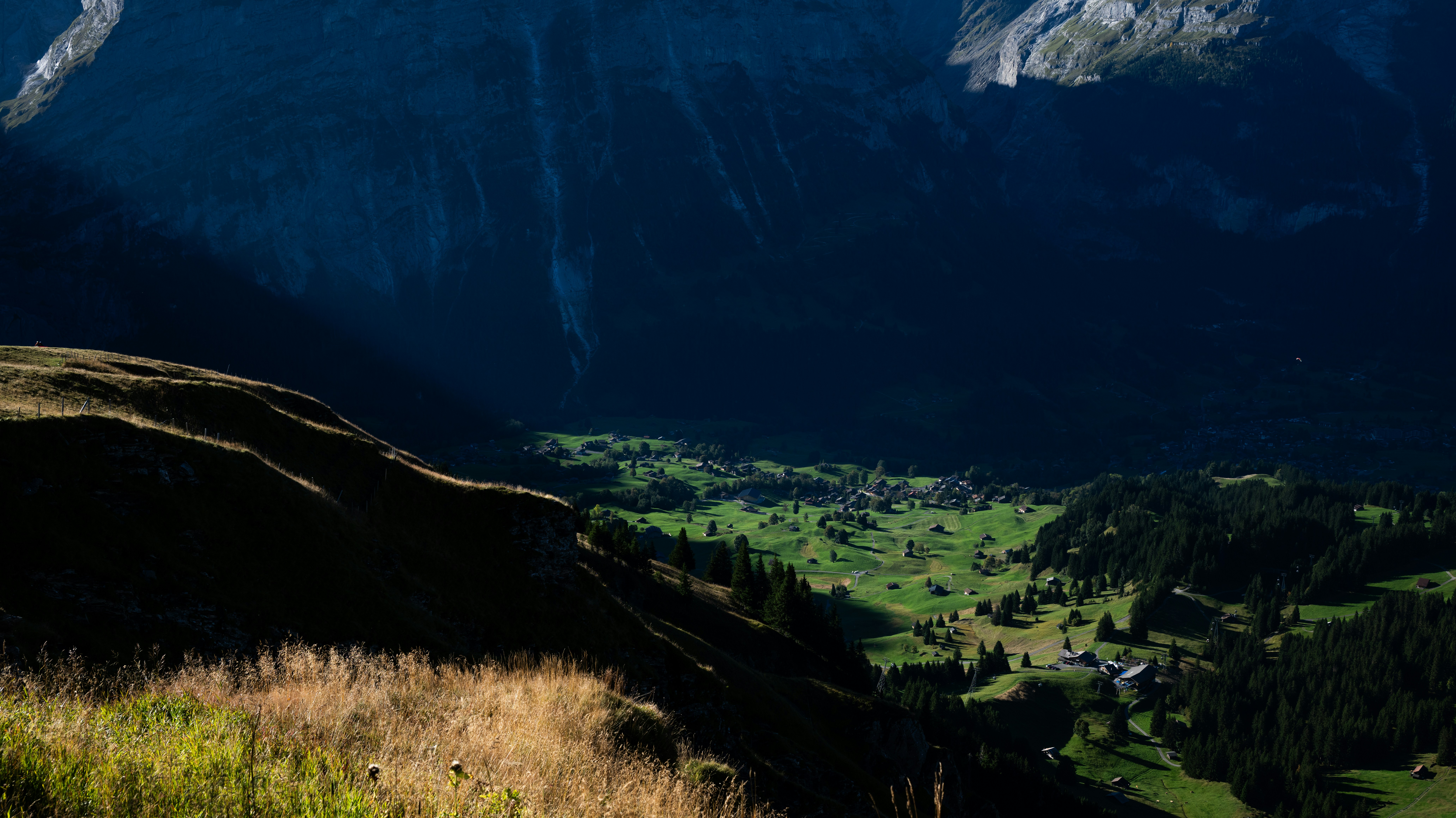Alpine Valley Light: Sunlit hamlets beneath shadowed peaks