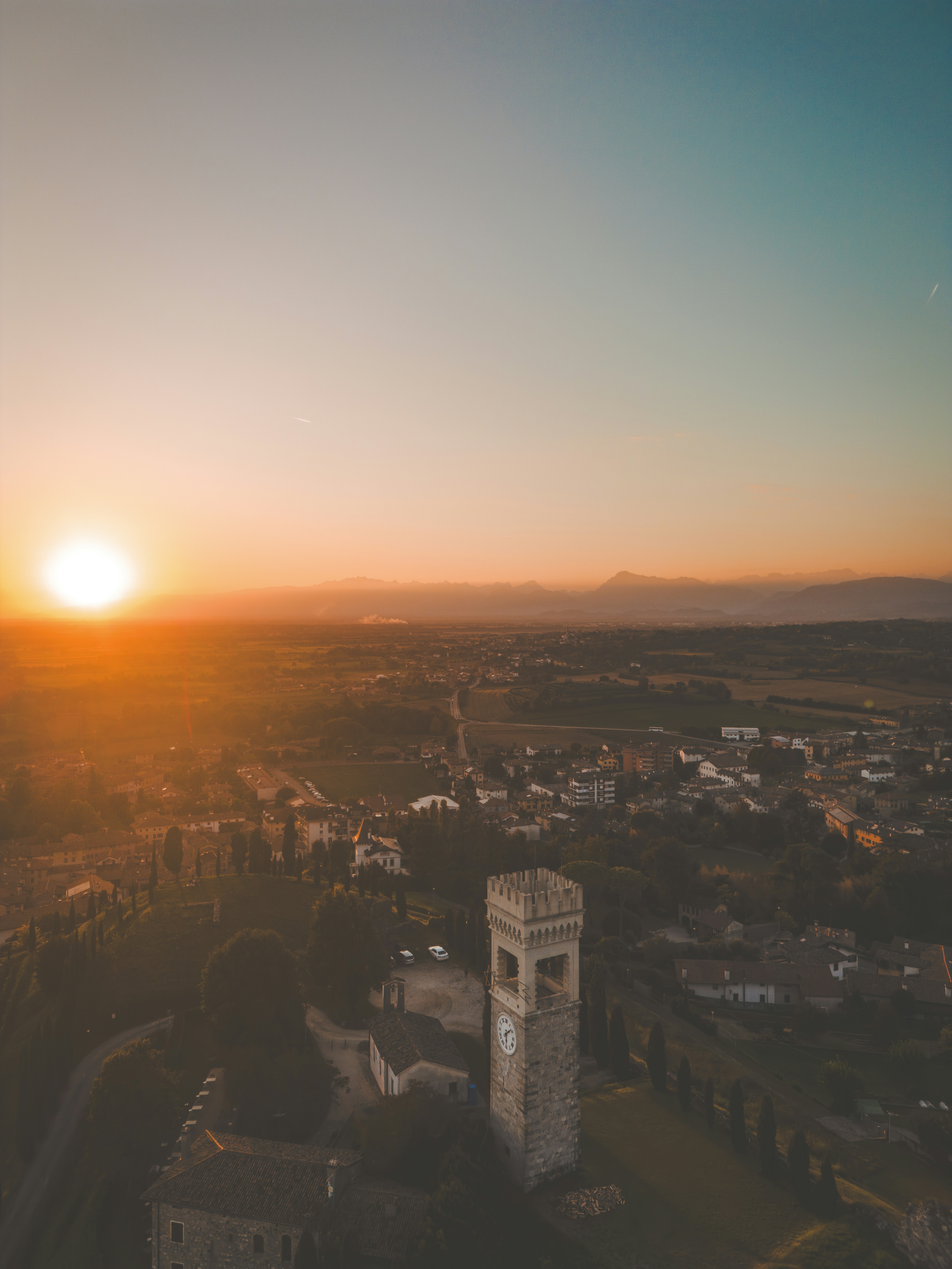 Sunset over a historic tower and village.