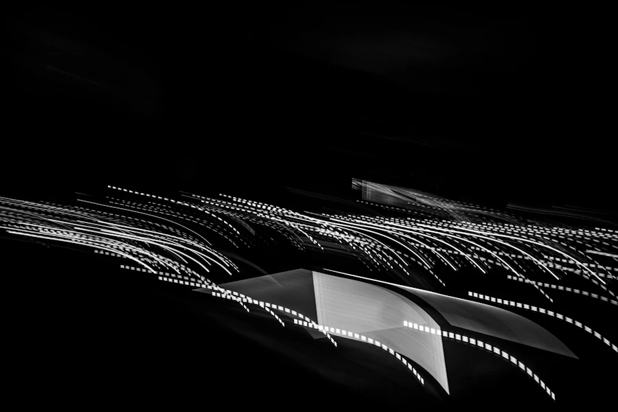 Black-background abstract scene with sweeping white light trails and a bright angular central form. The composition feels like long-exposure motion with layered streaks across the frame.