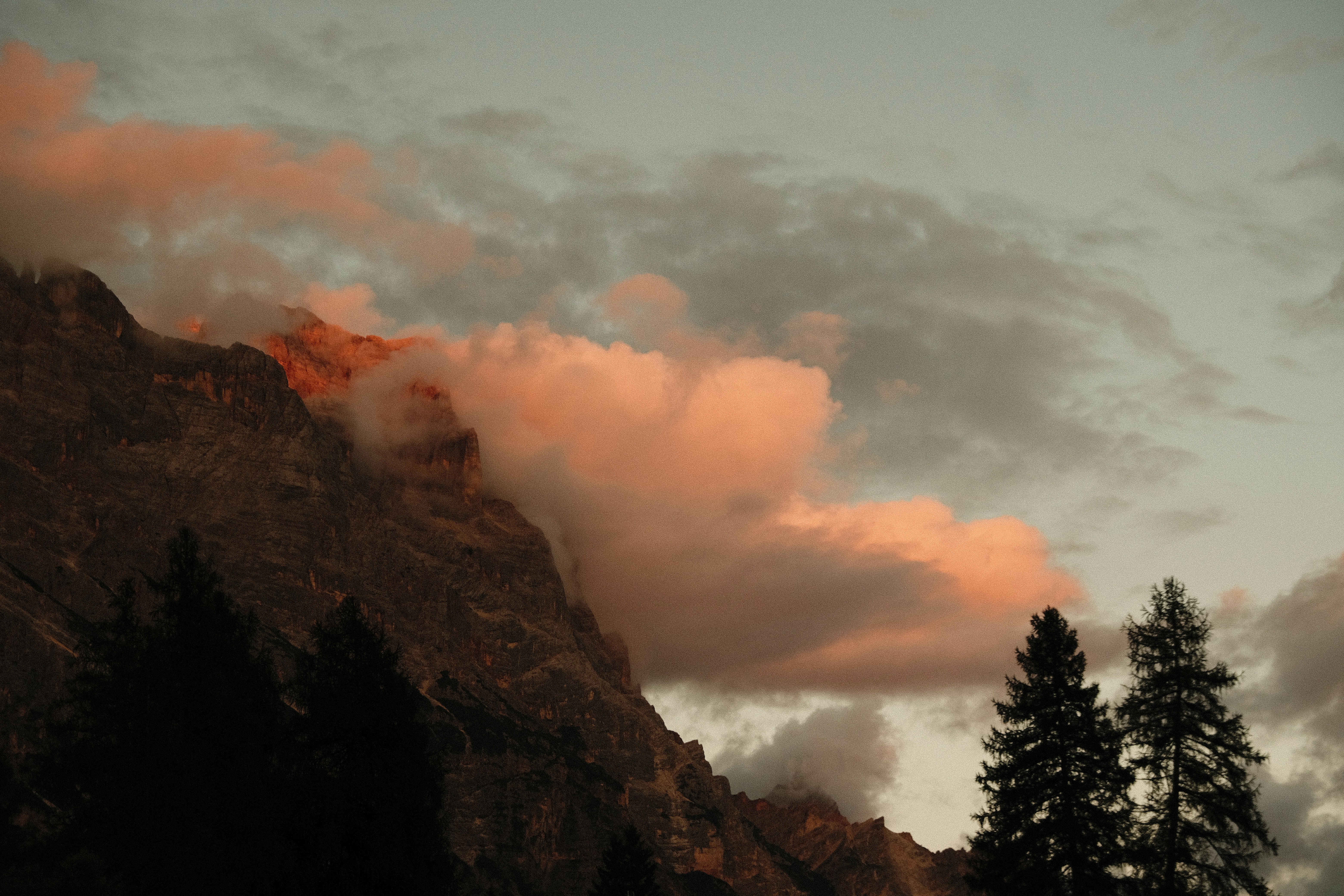 Mountain peak with pink clouds at sunset