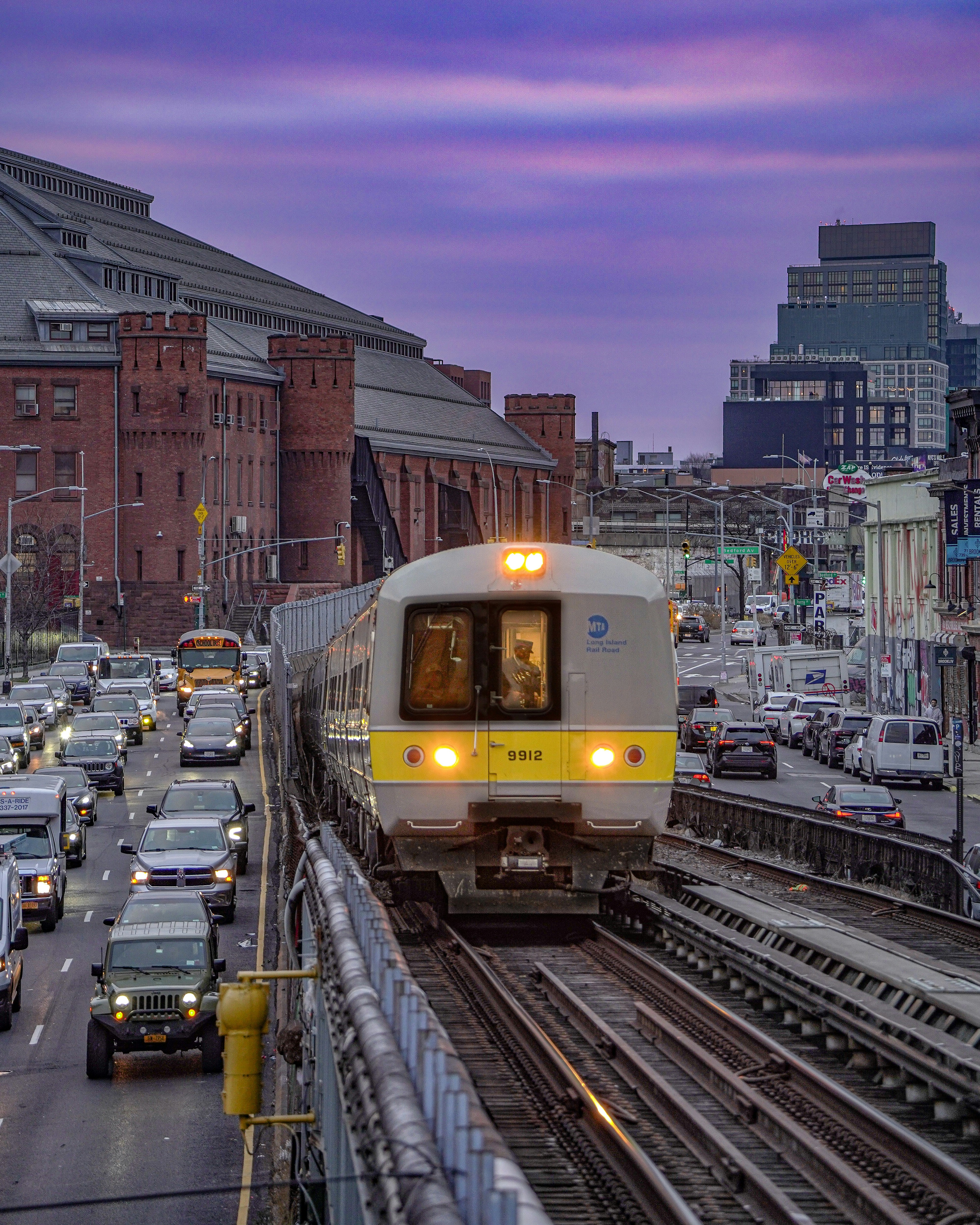 Castlemania - SMNYCMan | Train traveling on elevated tracks with city traffic below.