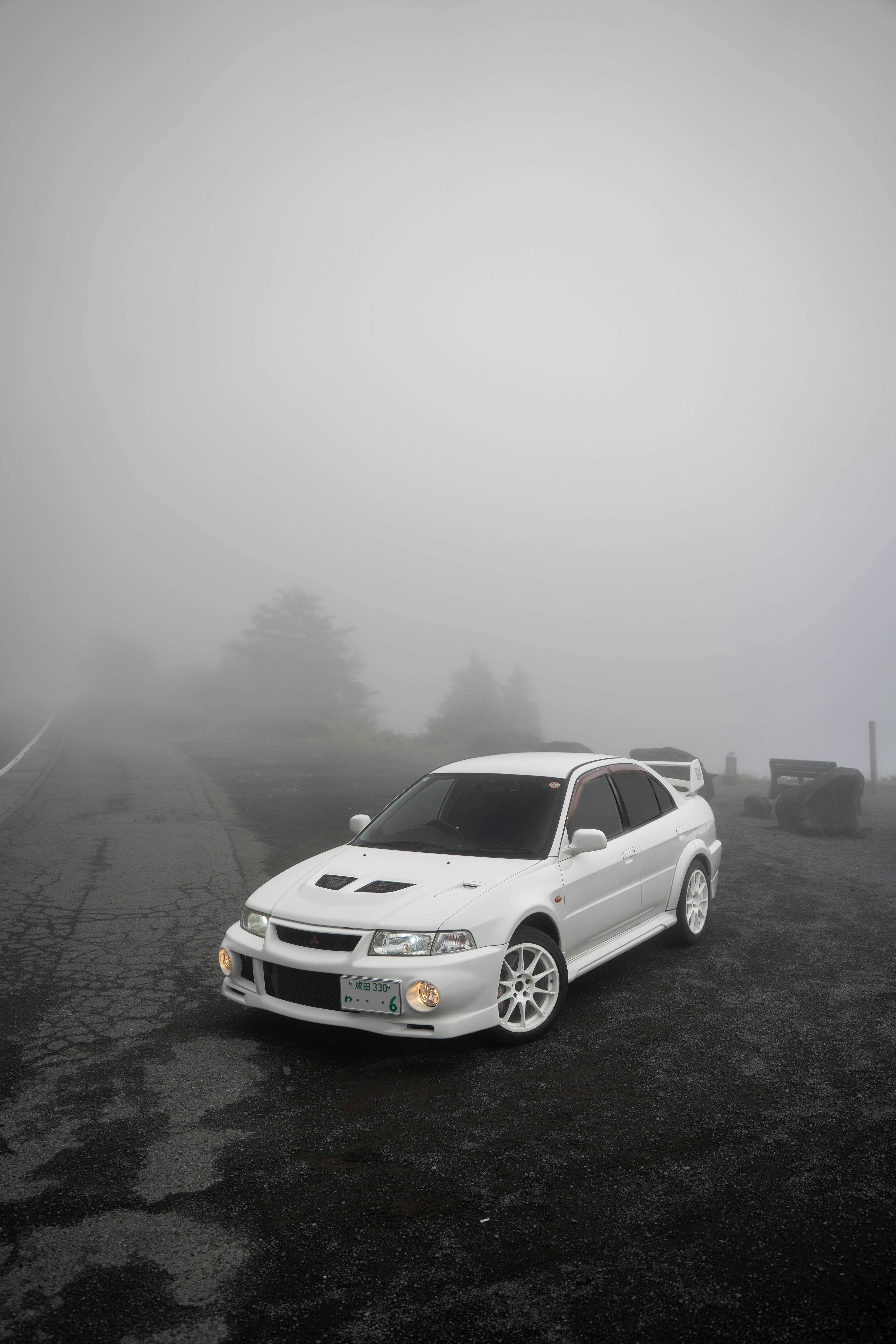 White sports car parked on a foggy road