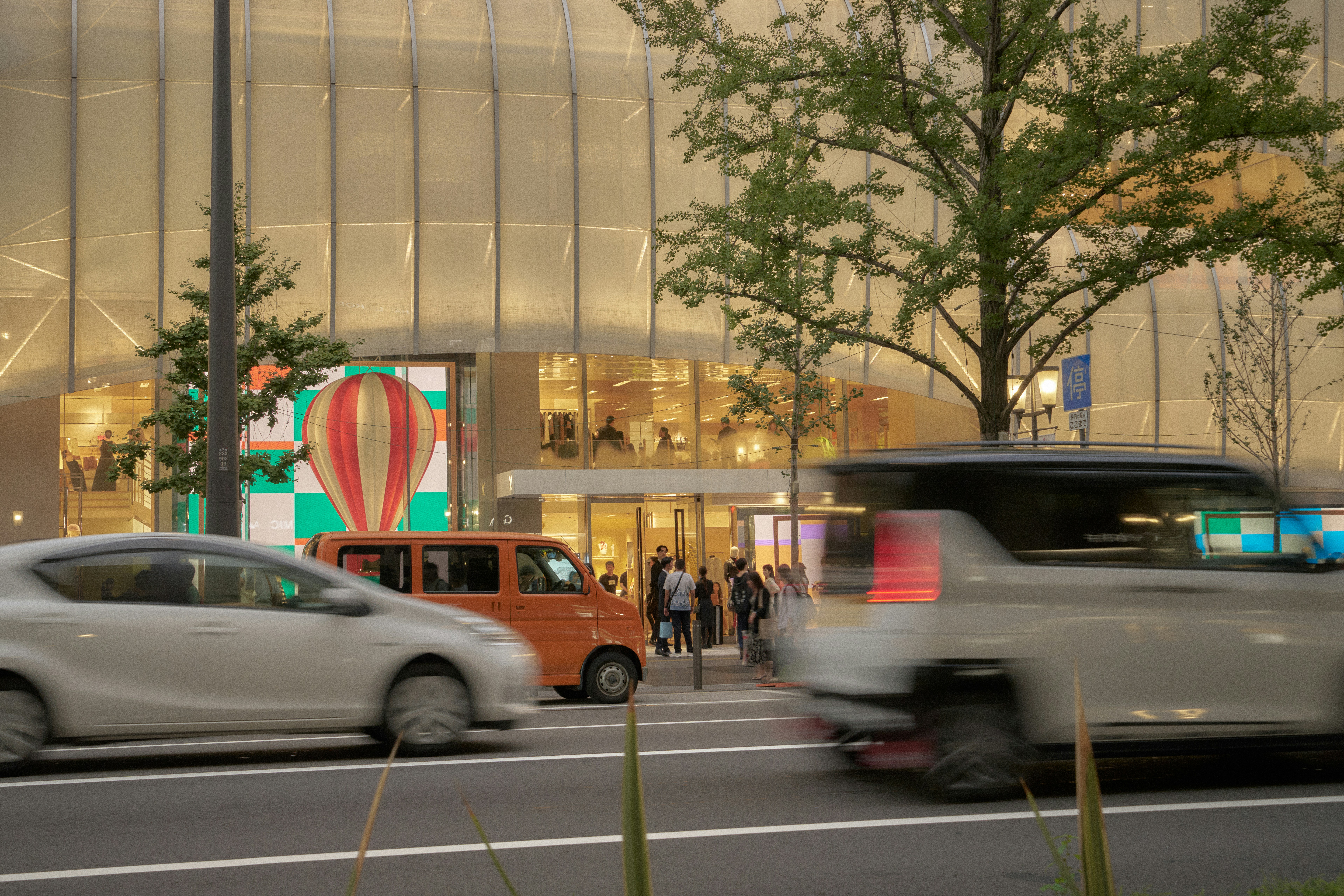 Cars passing by a modern building entrance