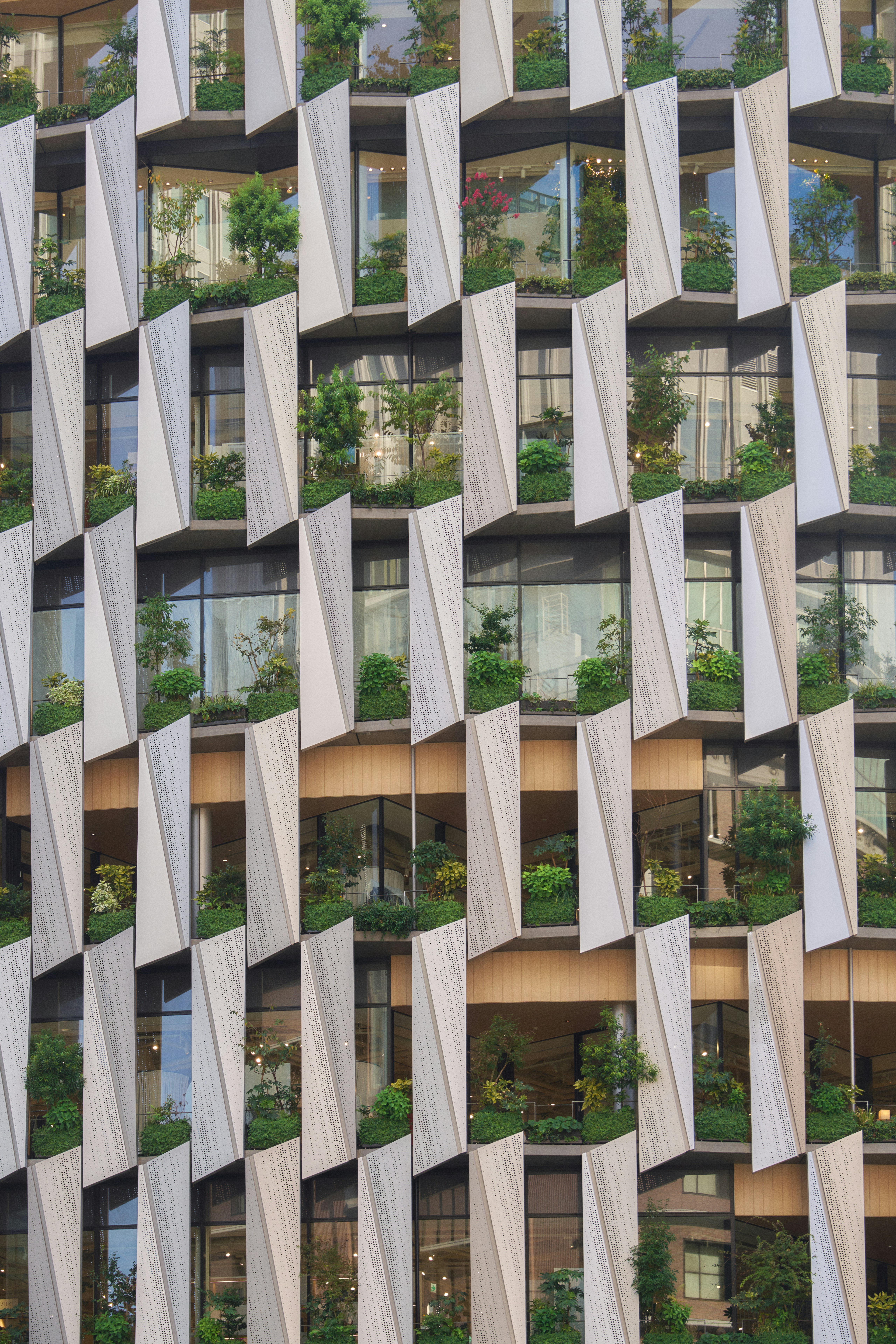 Modern building facade with many balconies and plants