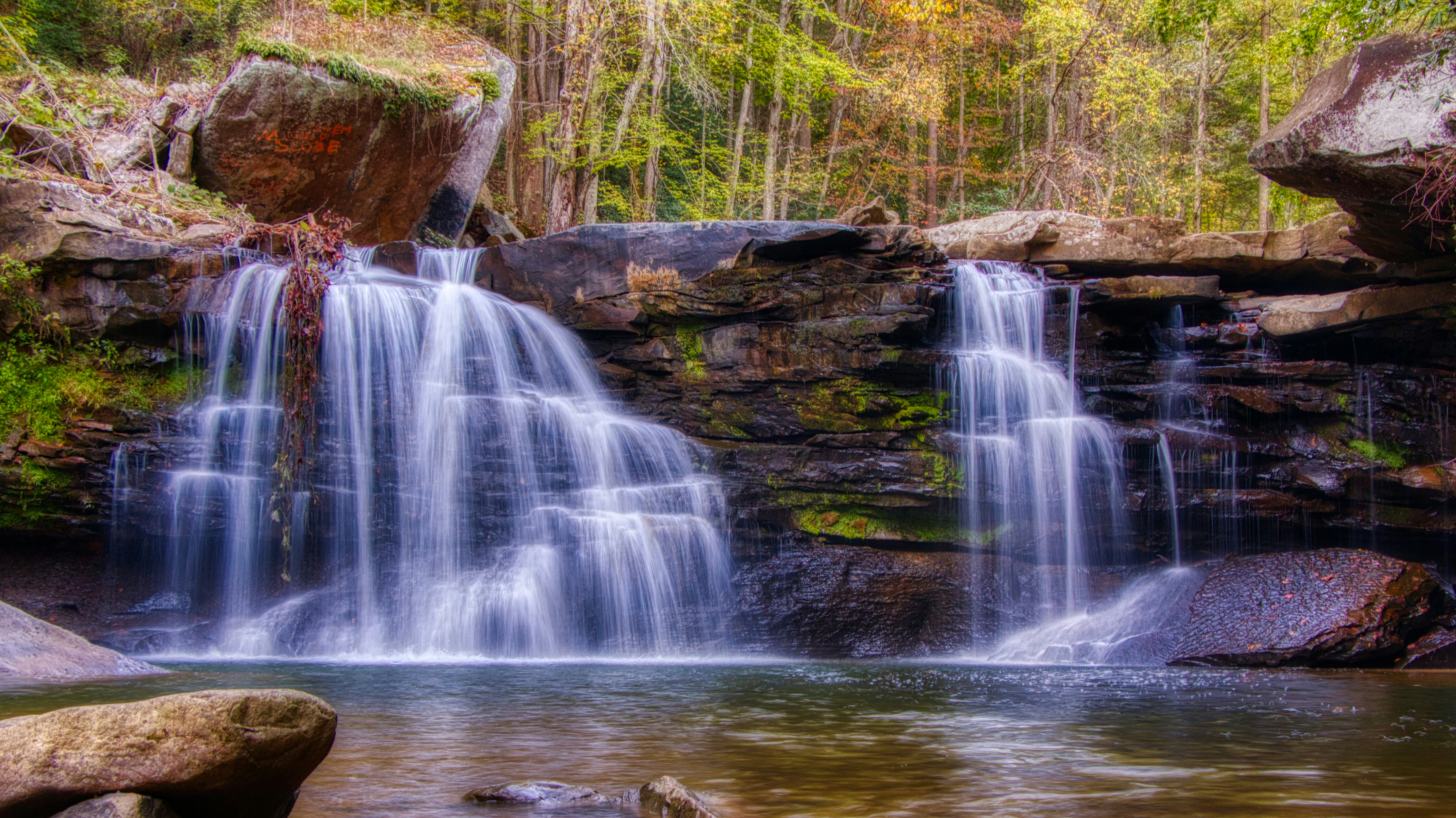 A beautiful waterfall cascades down rocks in a forest.