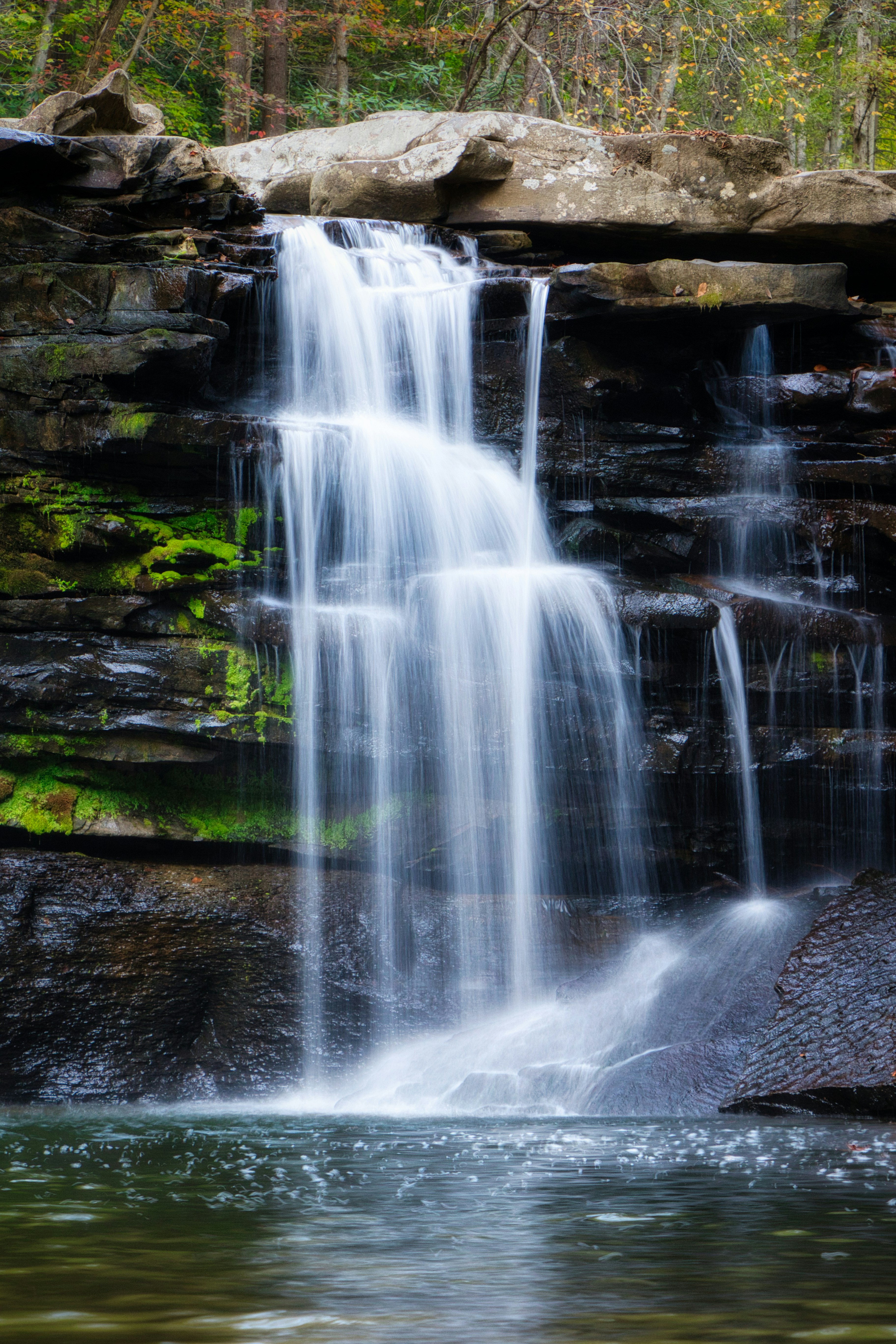 A serene waterfall cascades over mossy rocks.