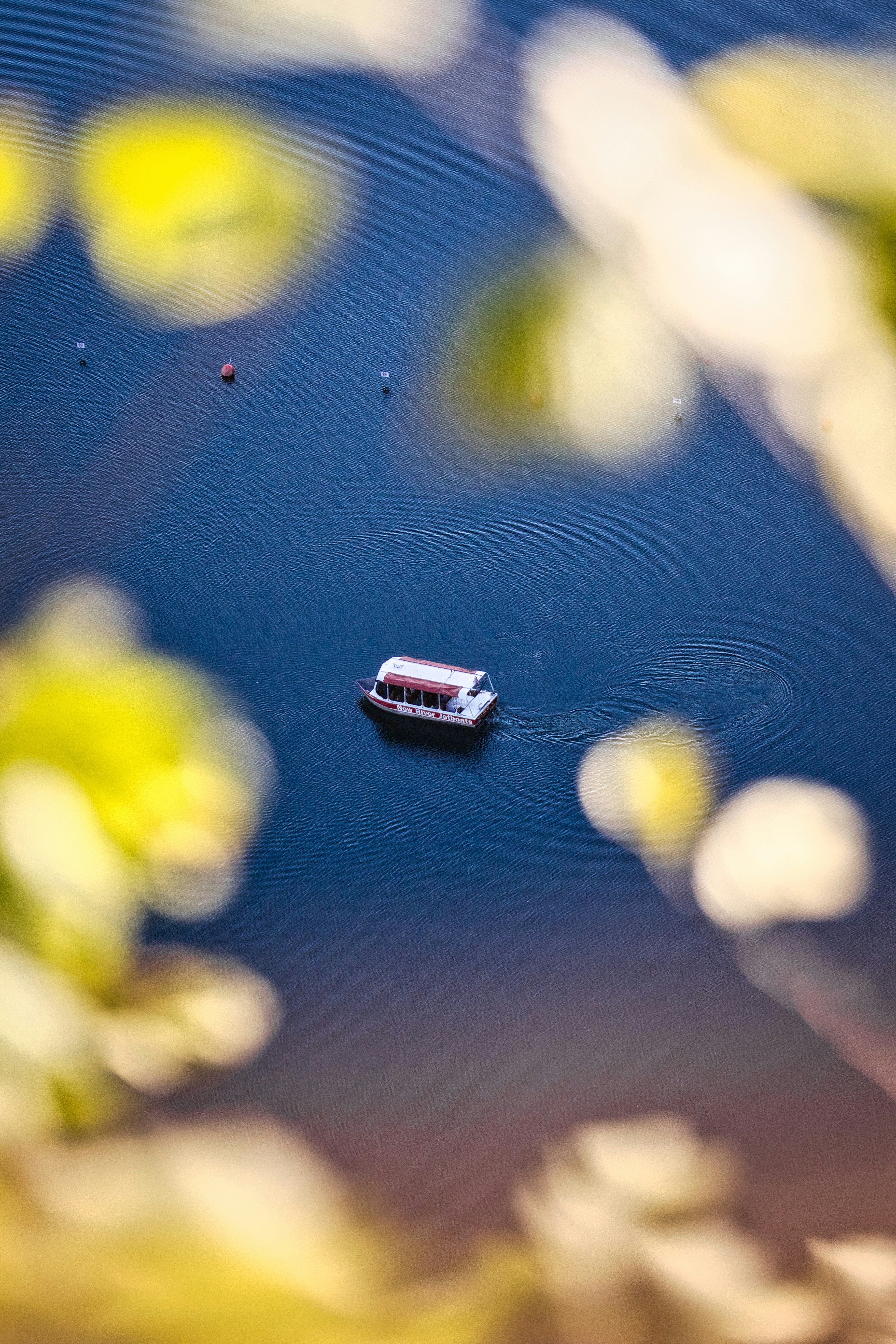 A small boat sails on a dark blue lake.