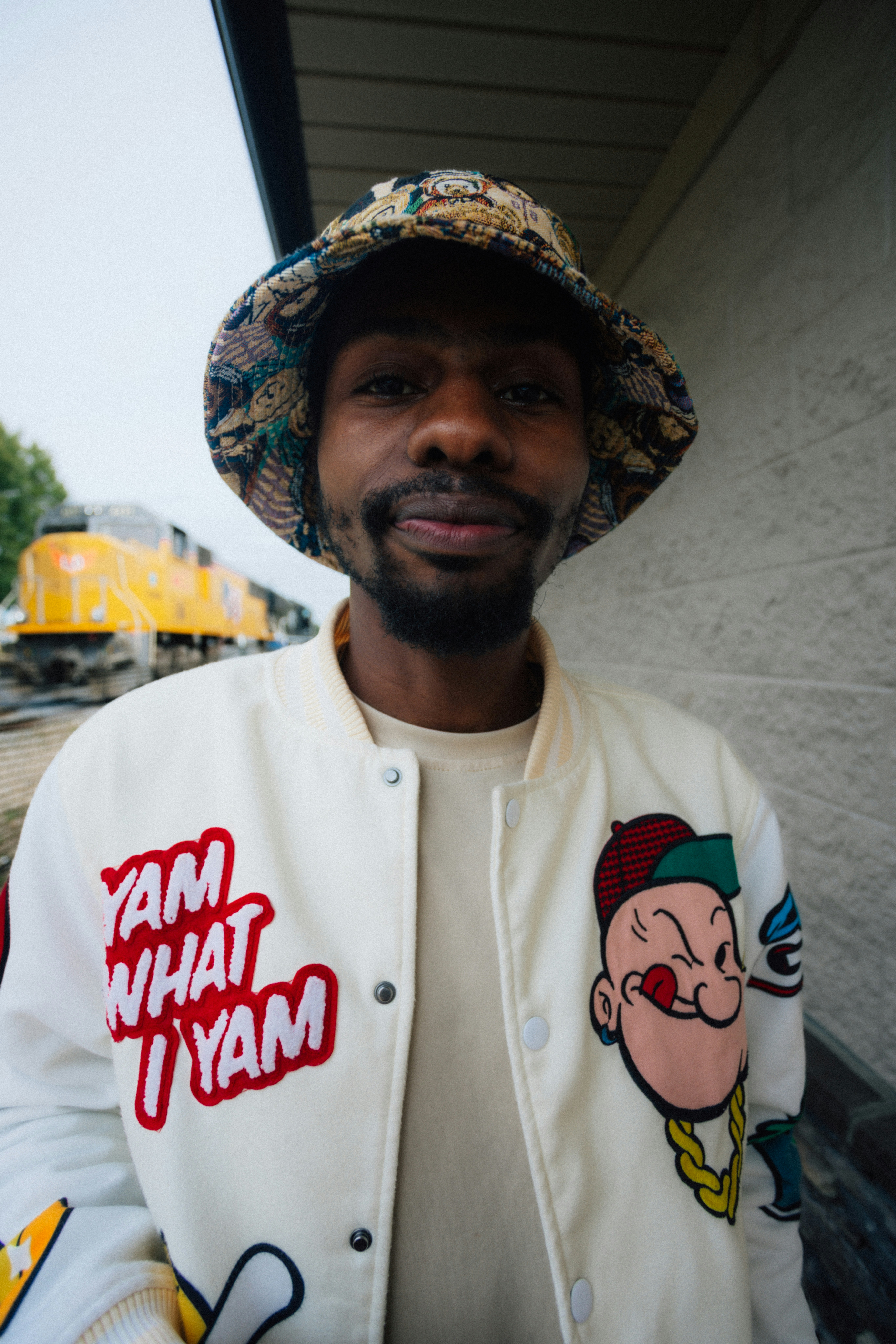Man wearing a bucket hat and bomber jacket