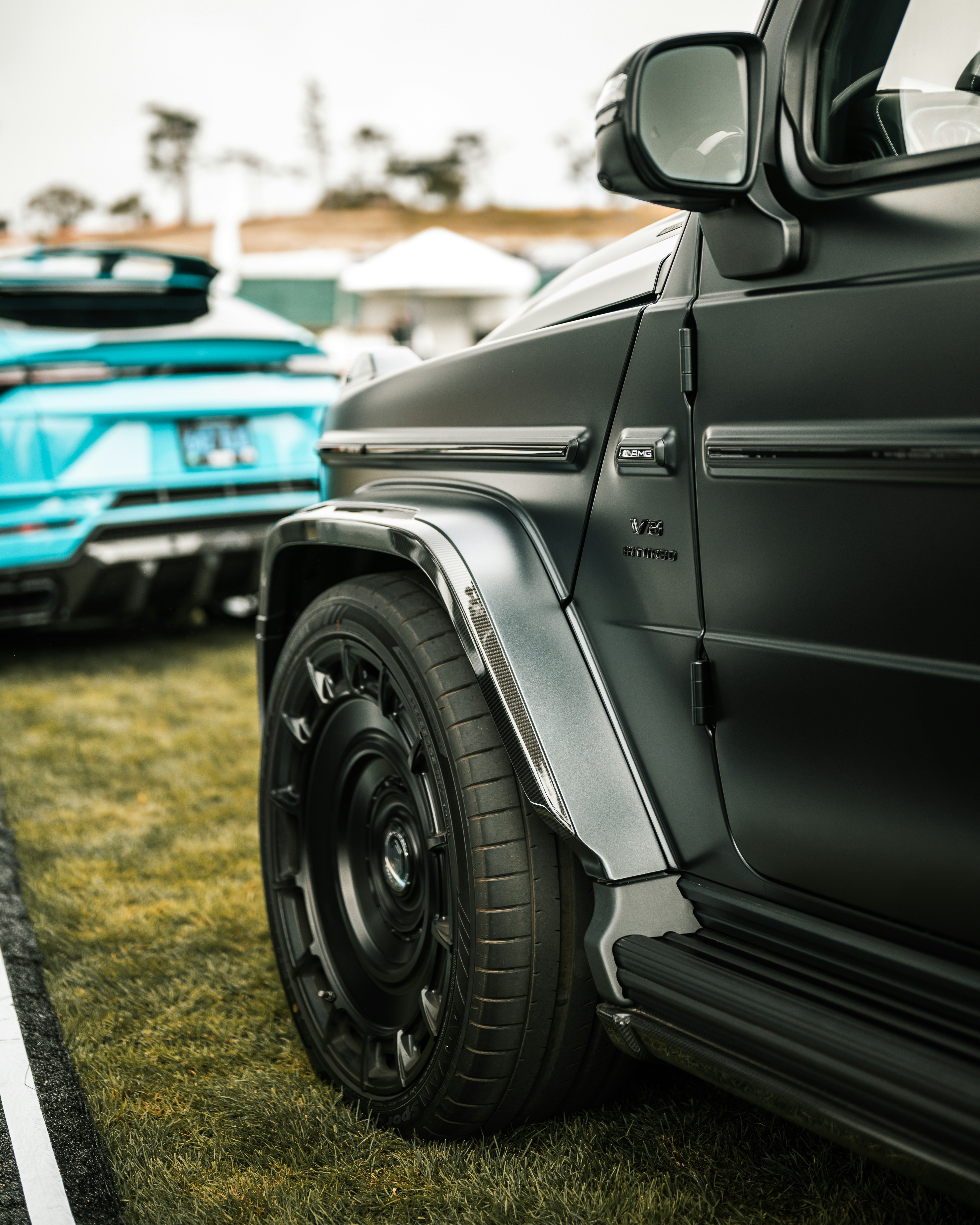 Rugged Chrome and Quiet Power: Close-Up of a Matte SUV's Wheel at a Car Show