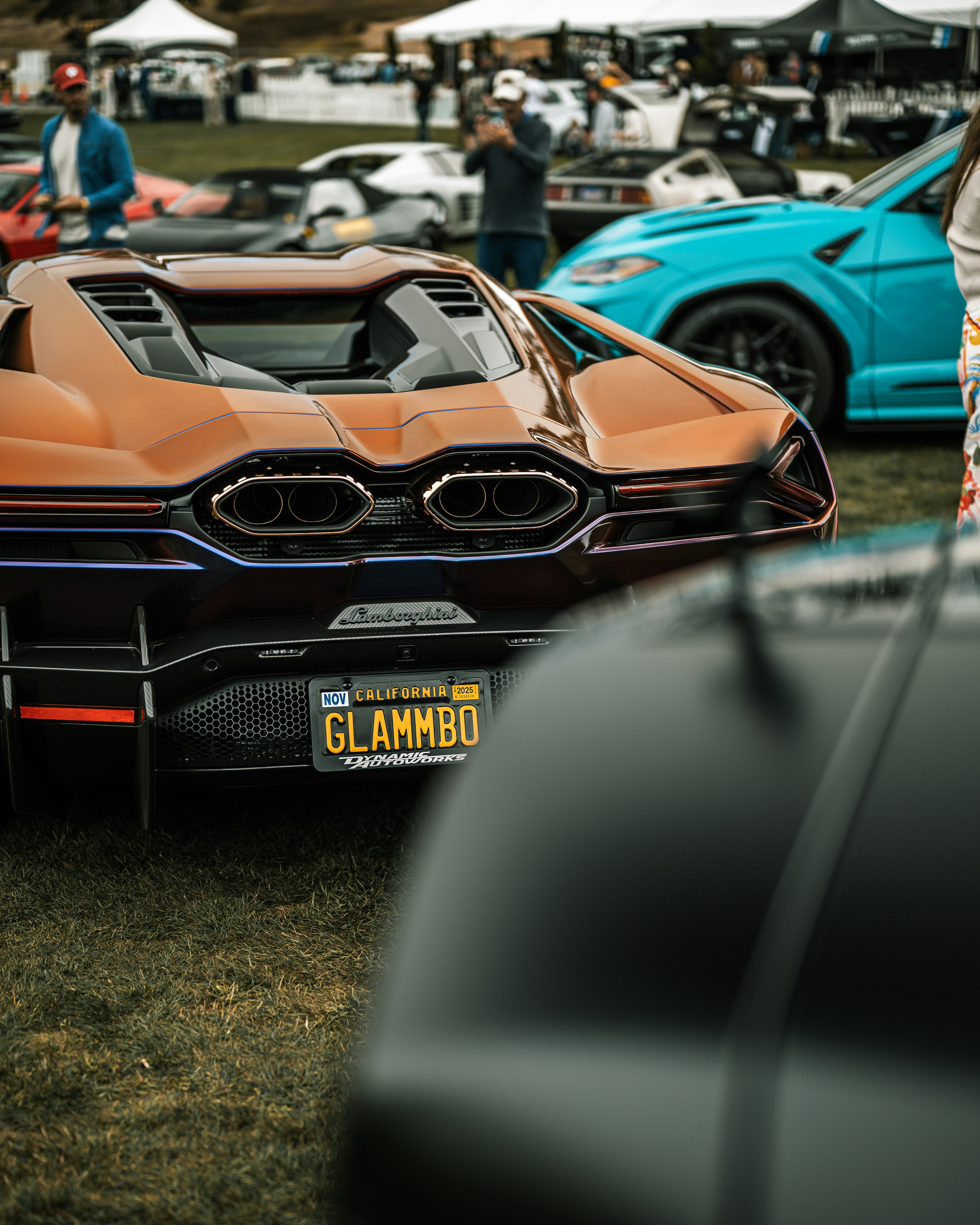 Orange Hypercar Rear: Twin Exhausts in a Sunlit Car Show Meadow