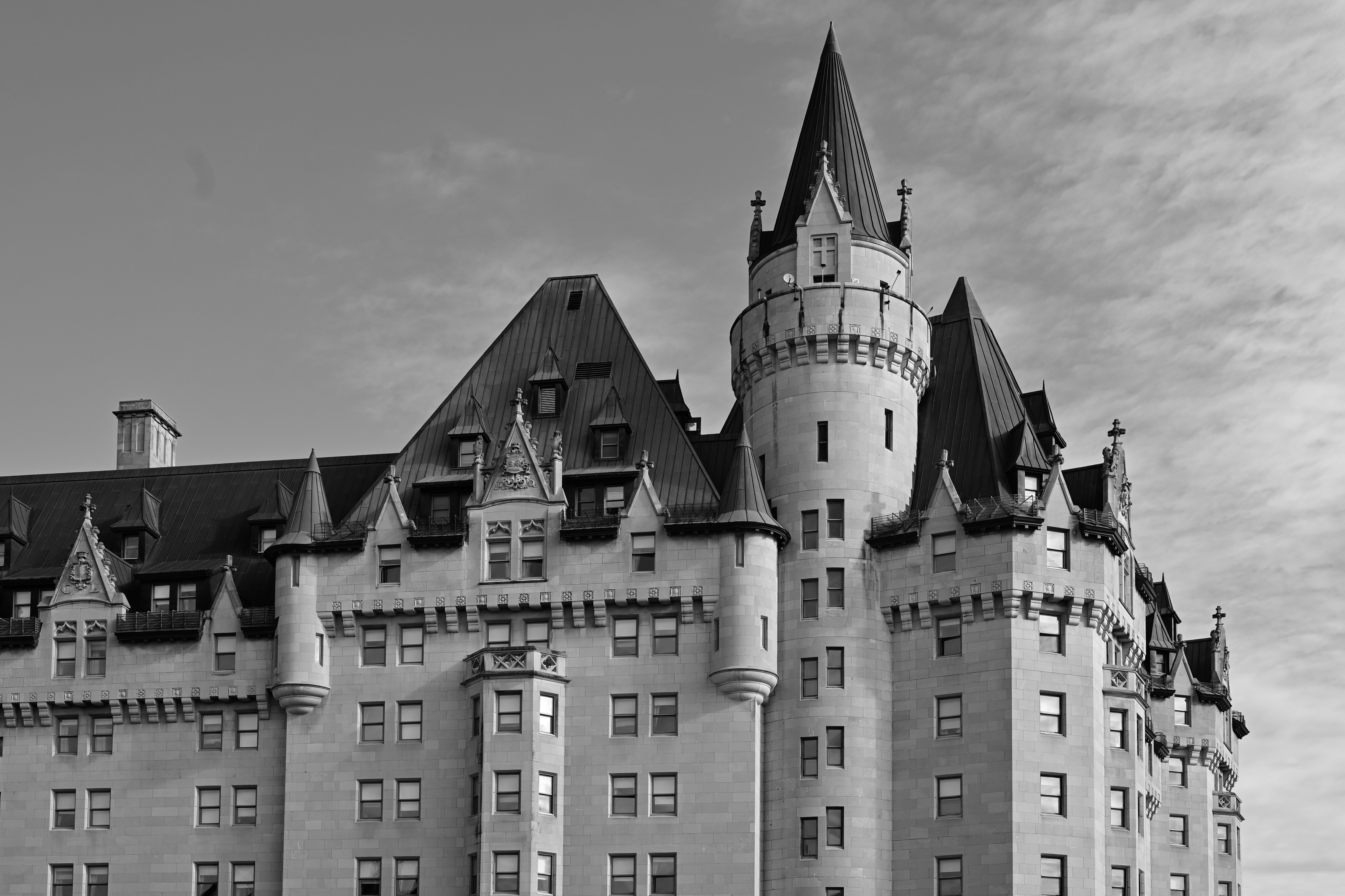 Monochrome Citadel: Tall Towers Reach Beneath a Cloudy Sky