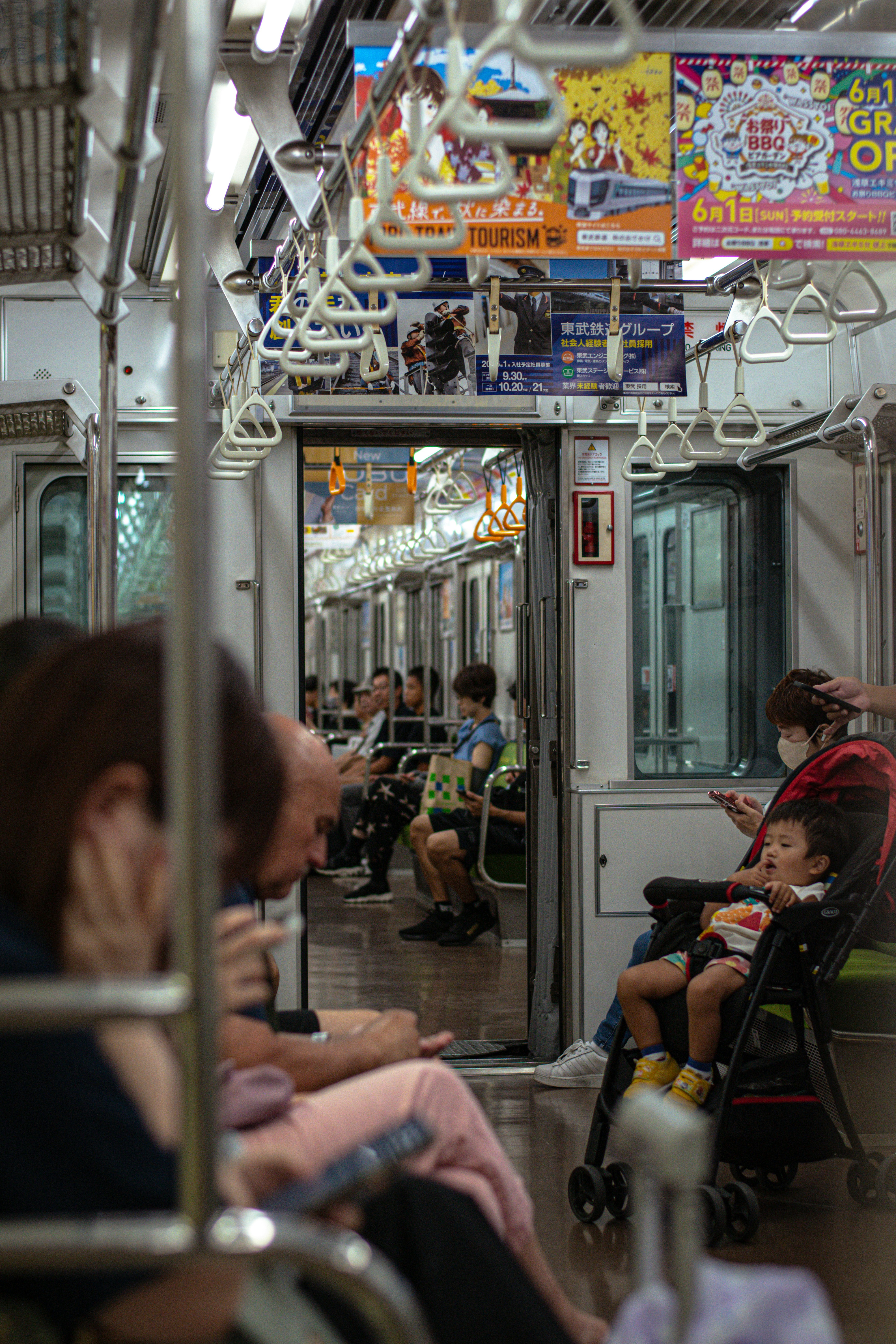 Passengers on a crowded train during daytime.
