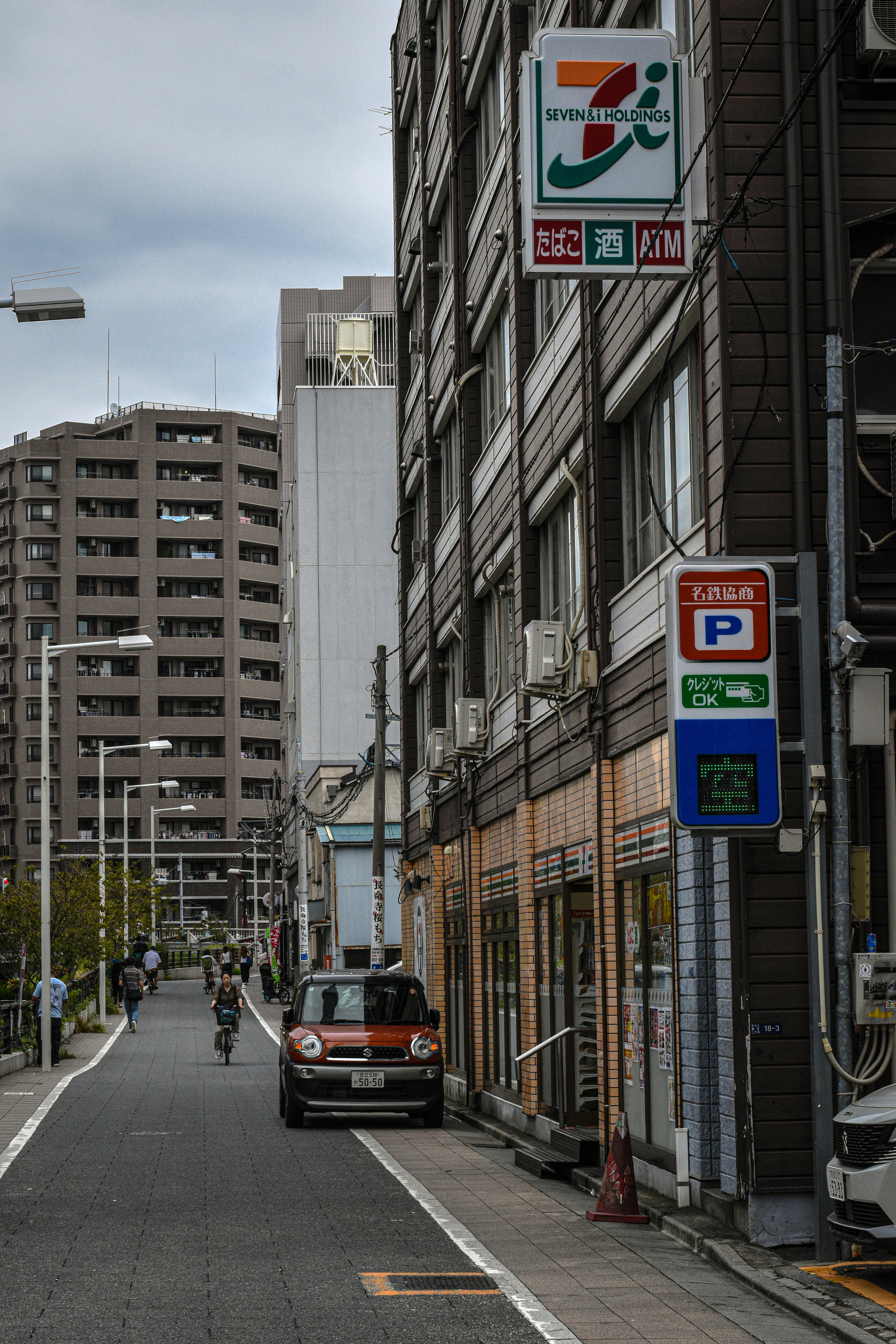 Street scene with seven eleven and parked car.