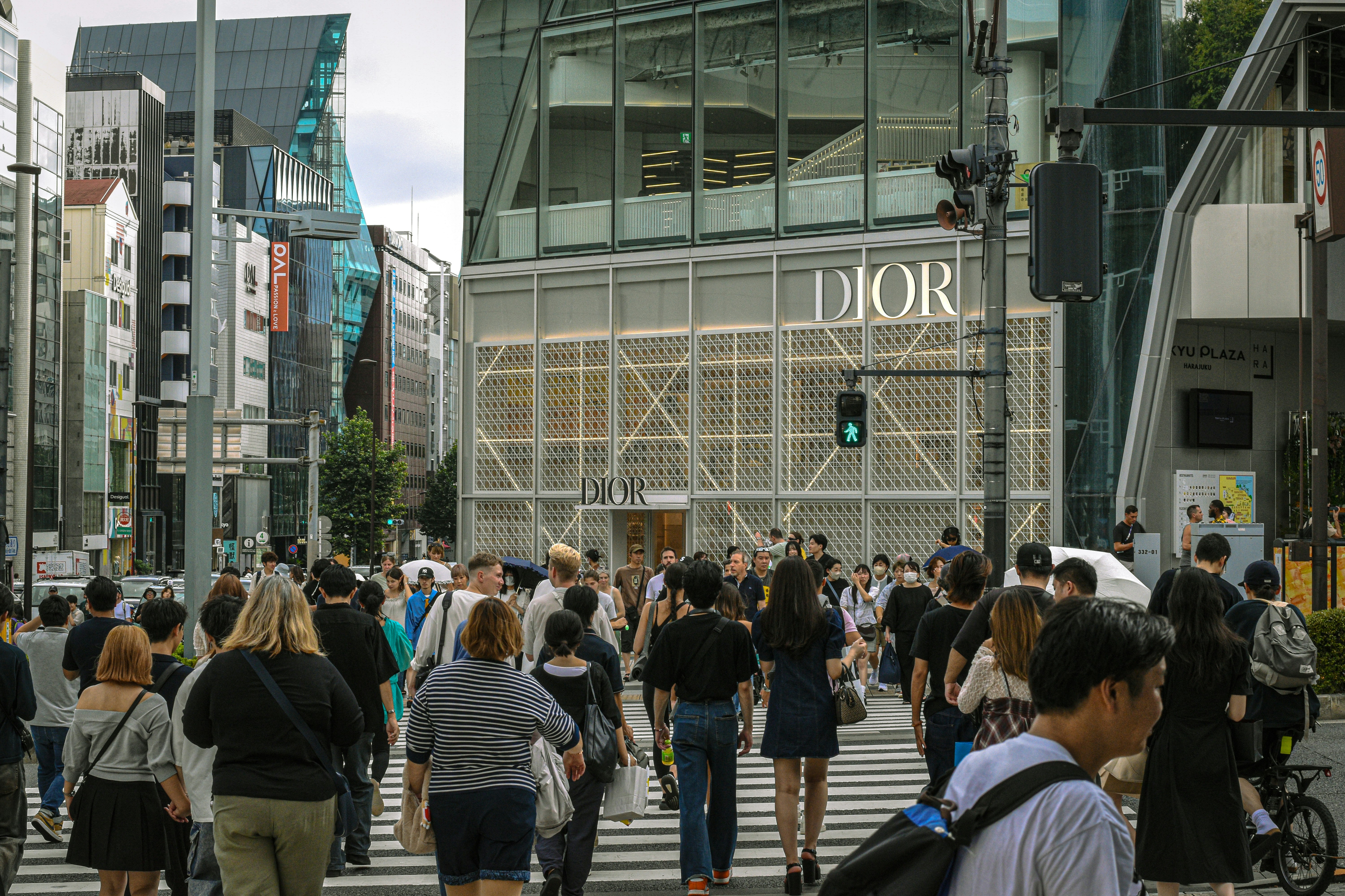 People crossing street in front of dior store