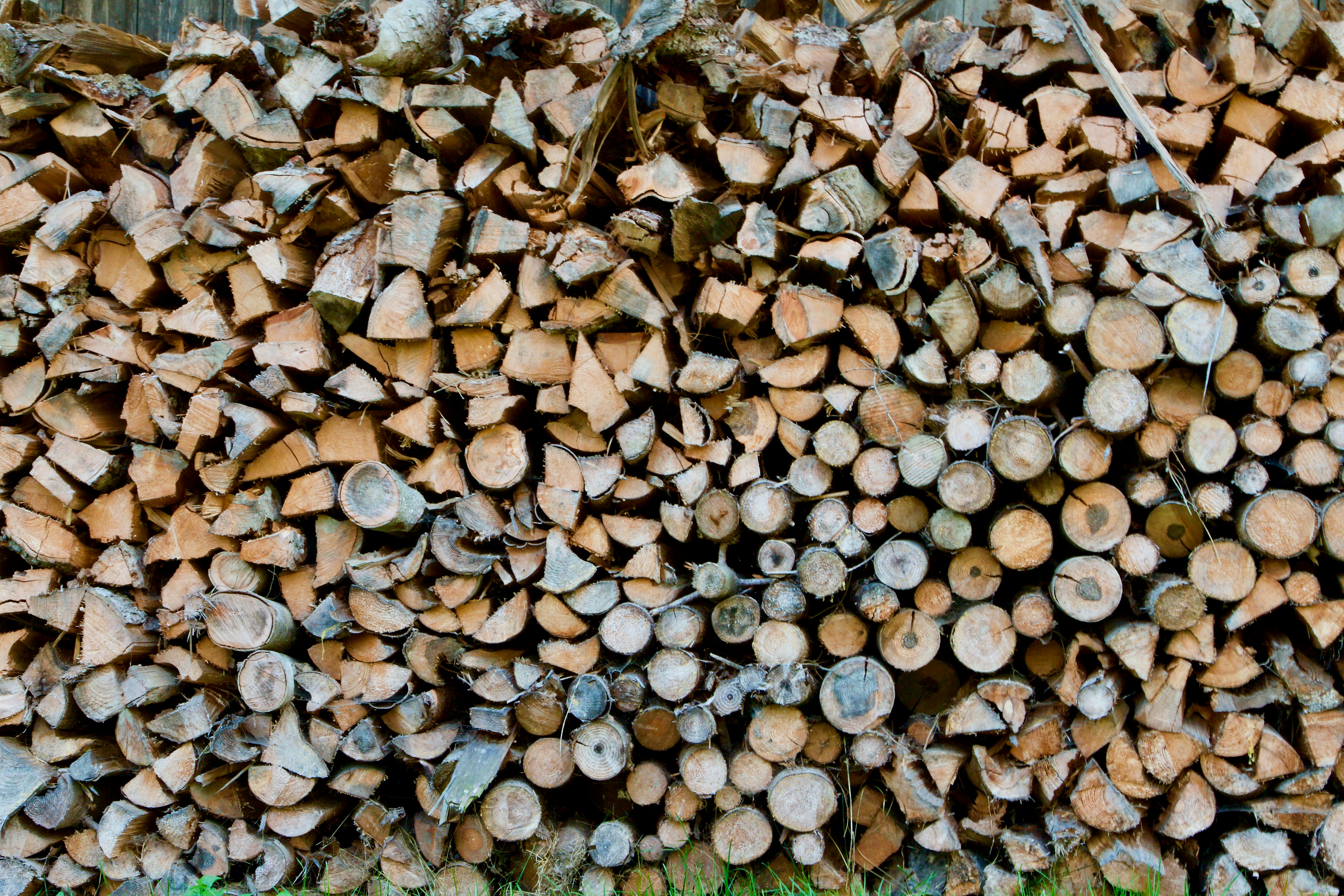 Pile of neatly stacked firewood logs of various sizes