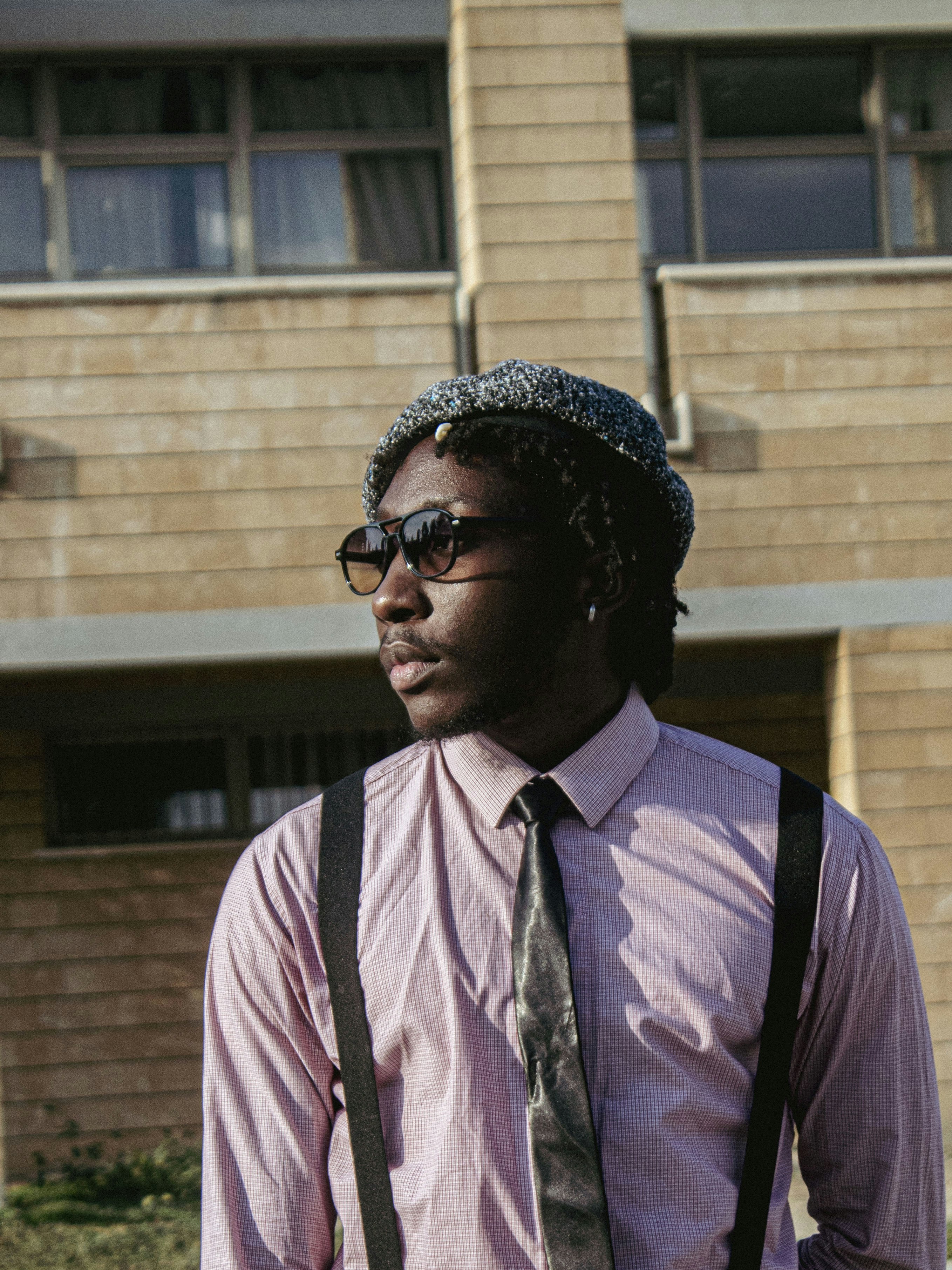 Man wearing a pink shirt, tie, and suspenders.