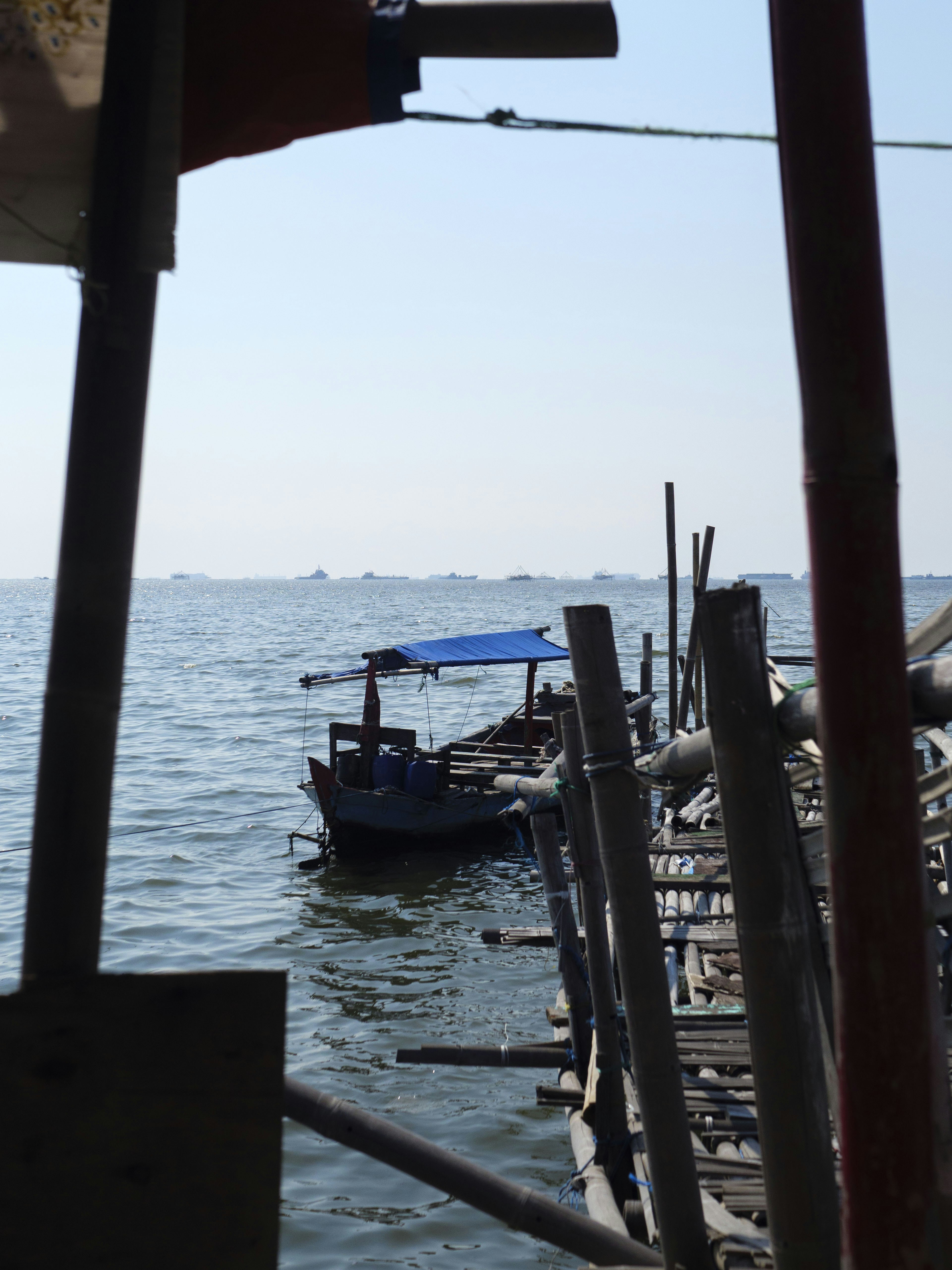 A small boat with a blue canopy on the water.