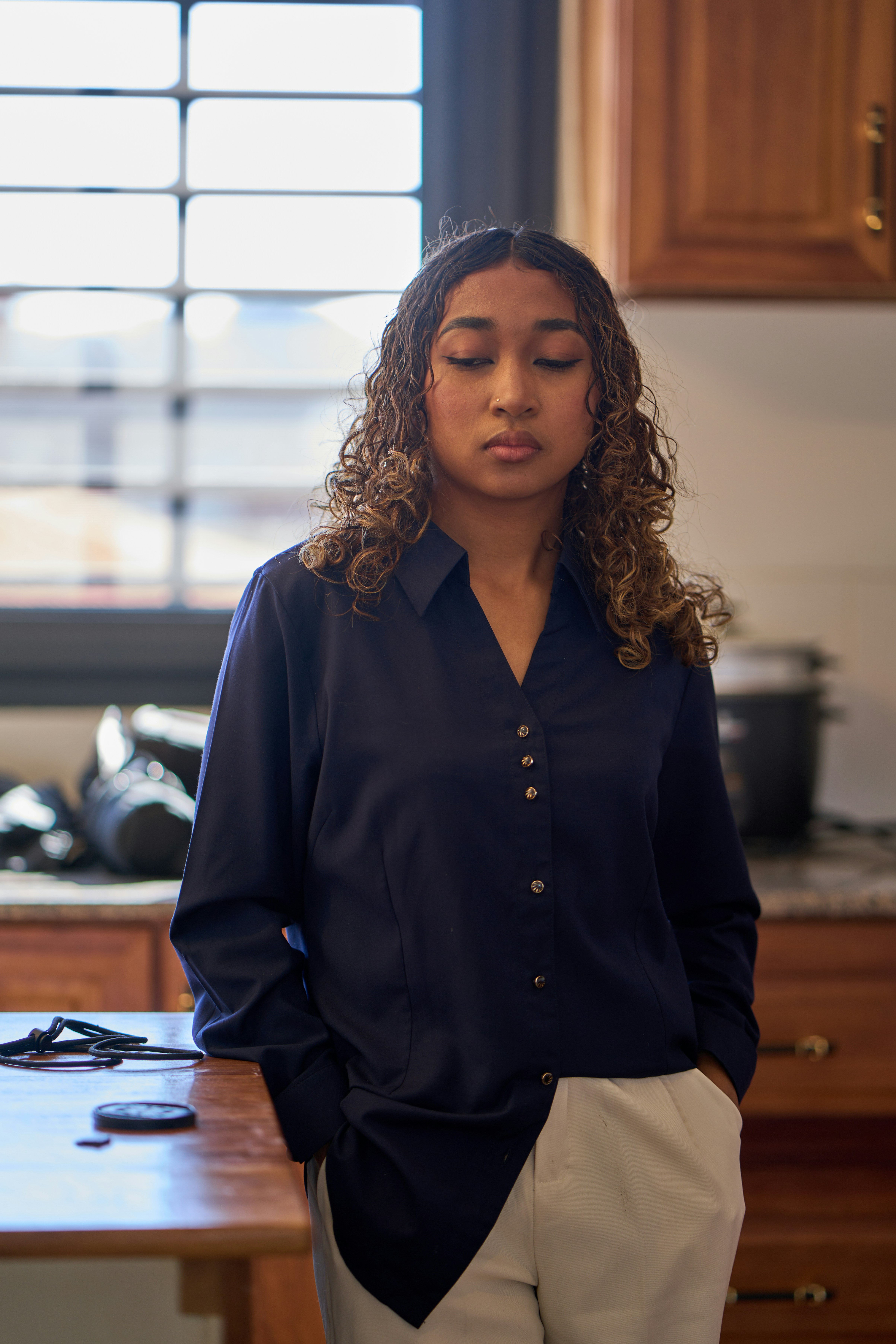 Young woman with eyes closed in a kitchen.
