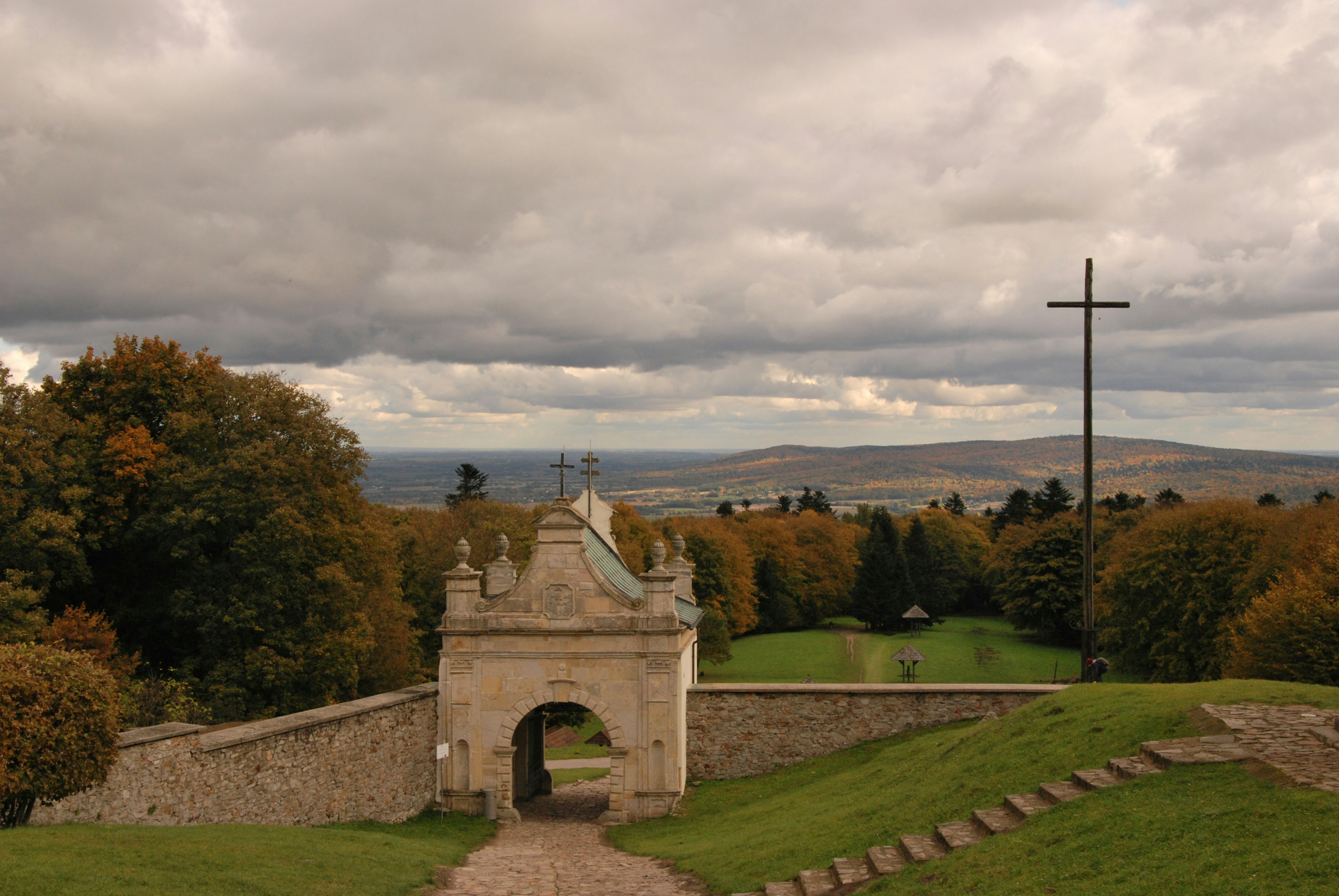 Stone archway with cross on hill overlooking landscape