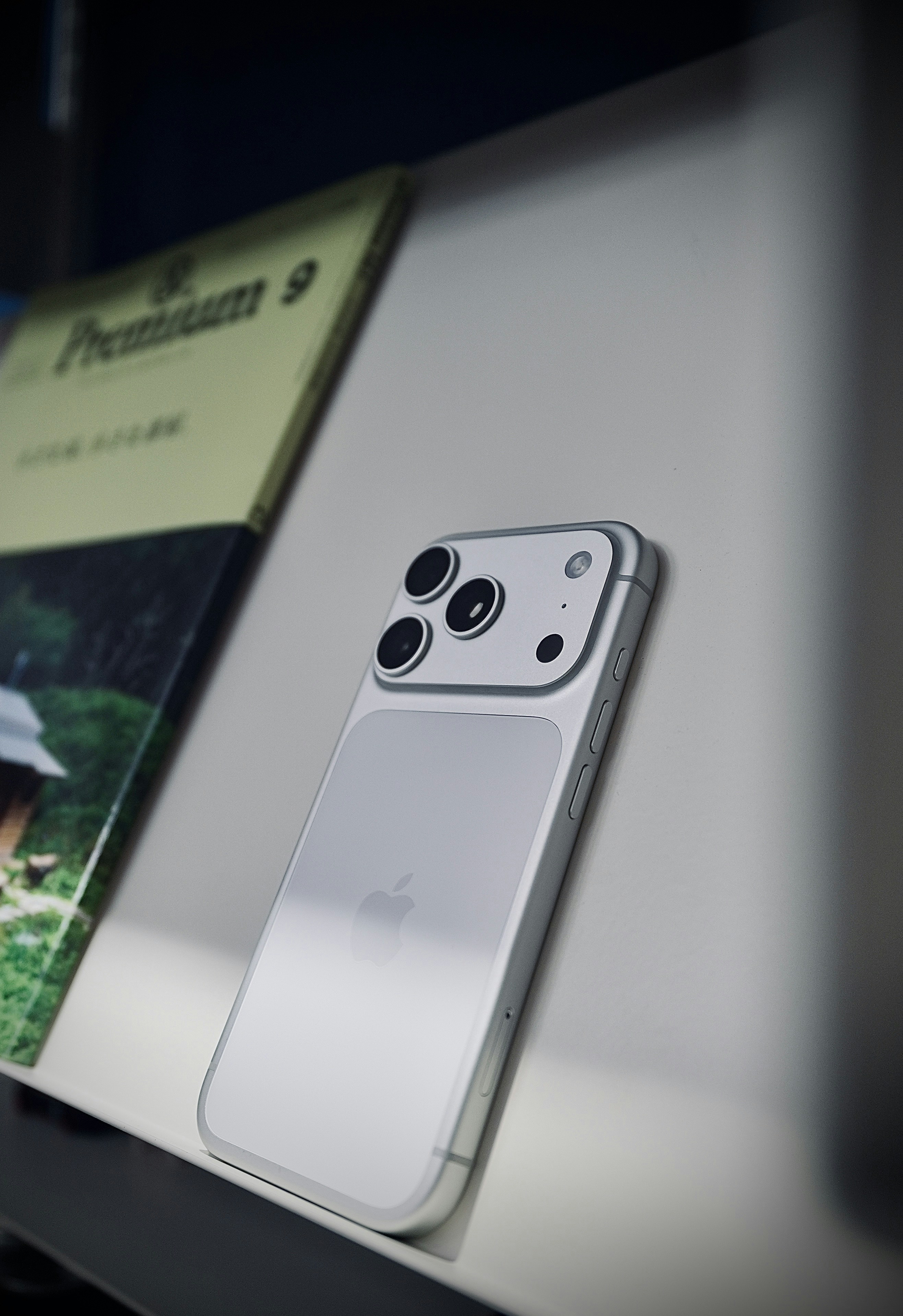 Sleek smartphone resting on a clean surface beside a vintage book, highlighting the contrast between modern technology and classic design.