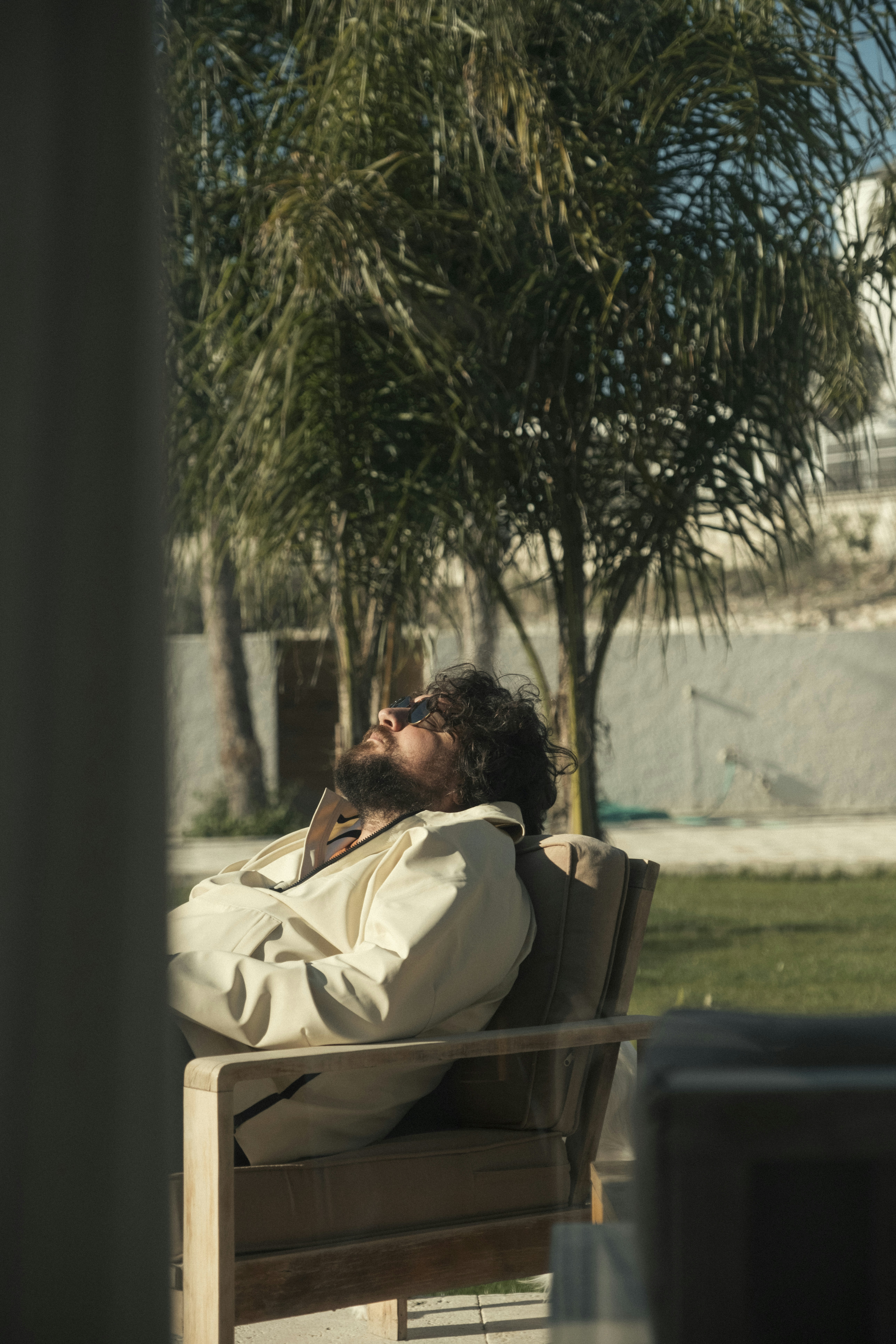 Man relaxing in a chair outdoors under trees