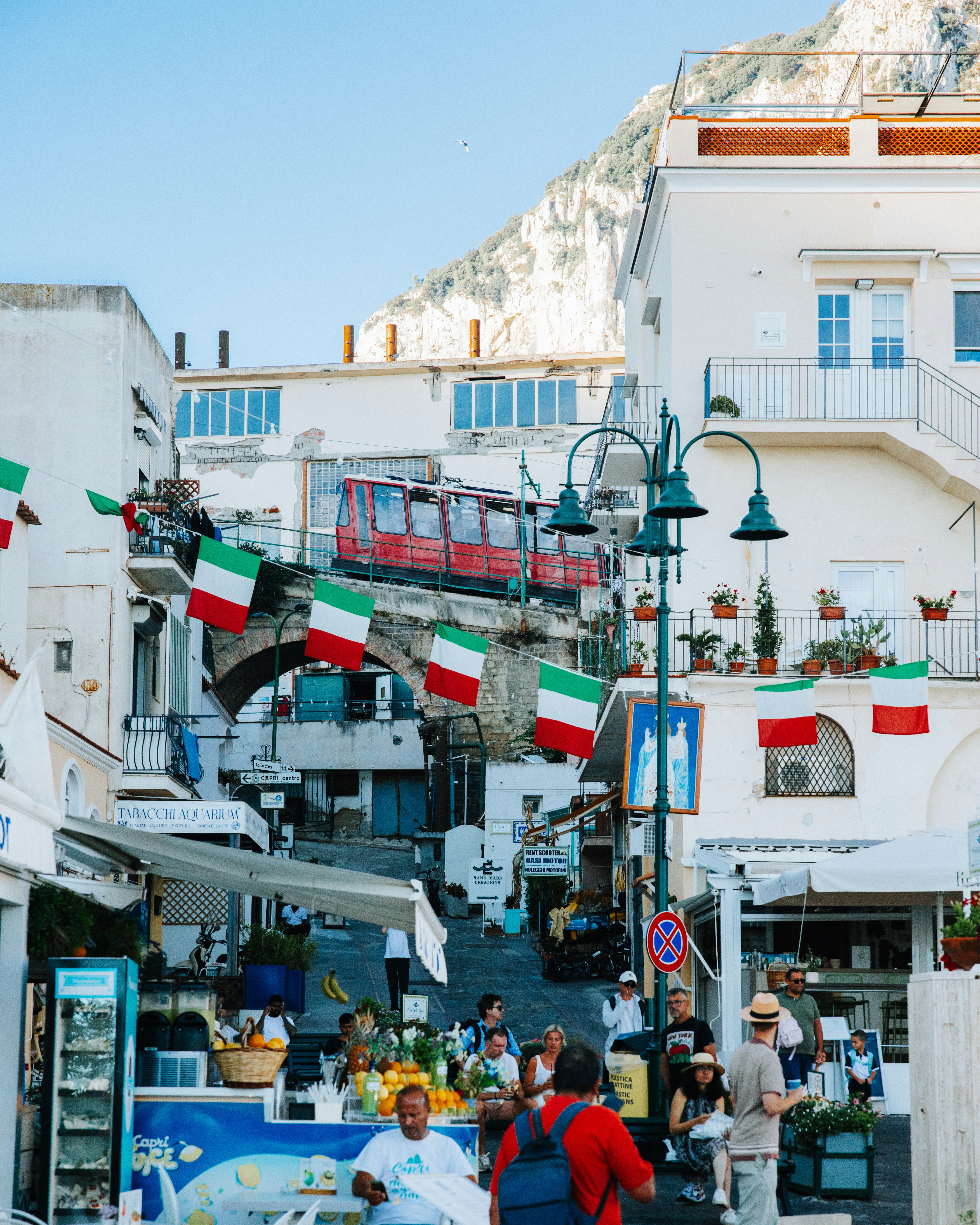 Italian flags and funicular on a sunny street.