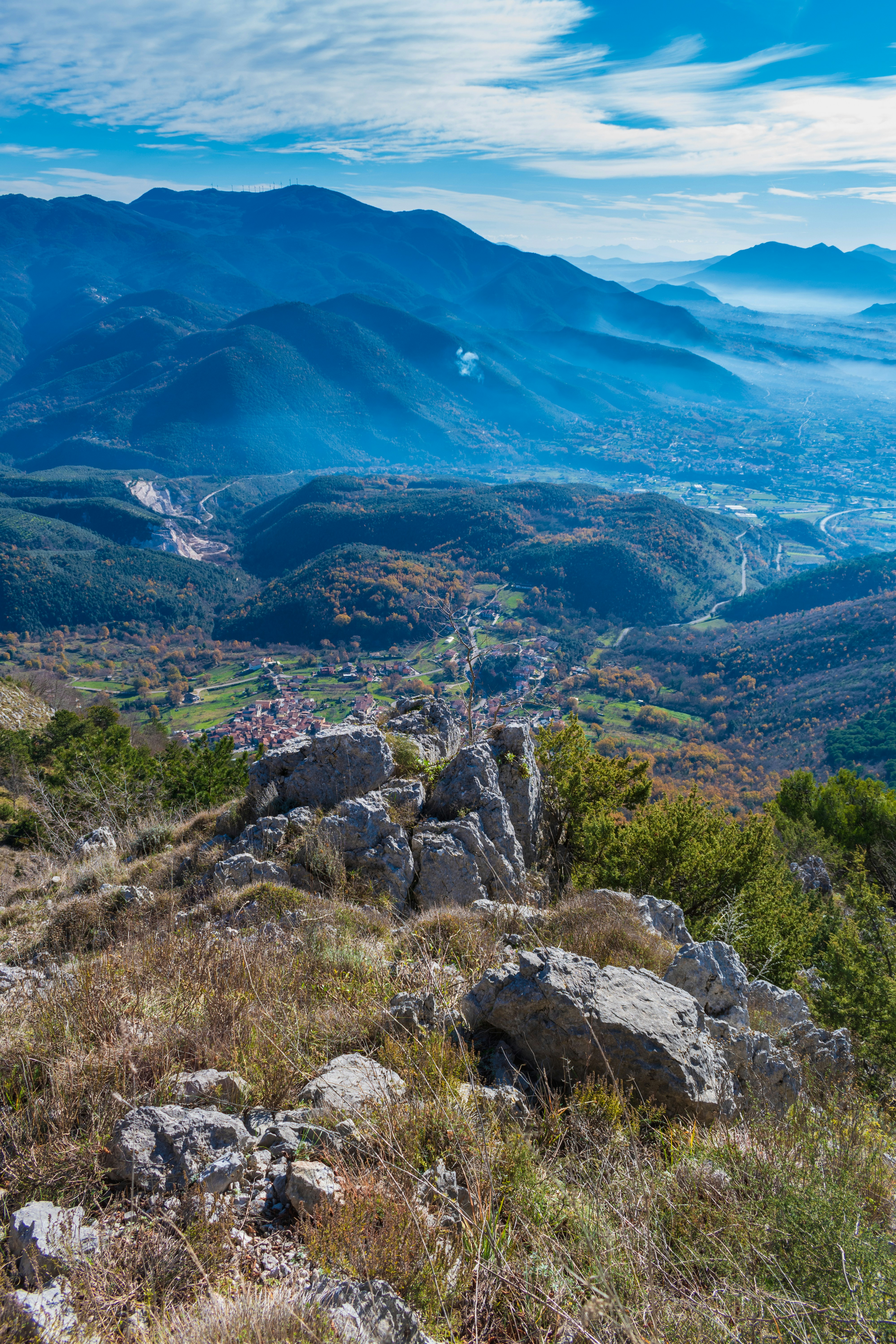 Mountain village nestled in a valley with distant haze.