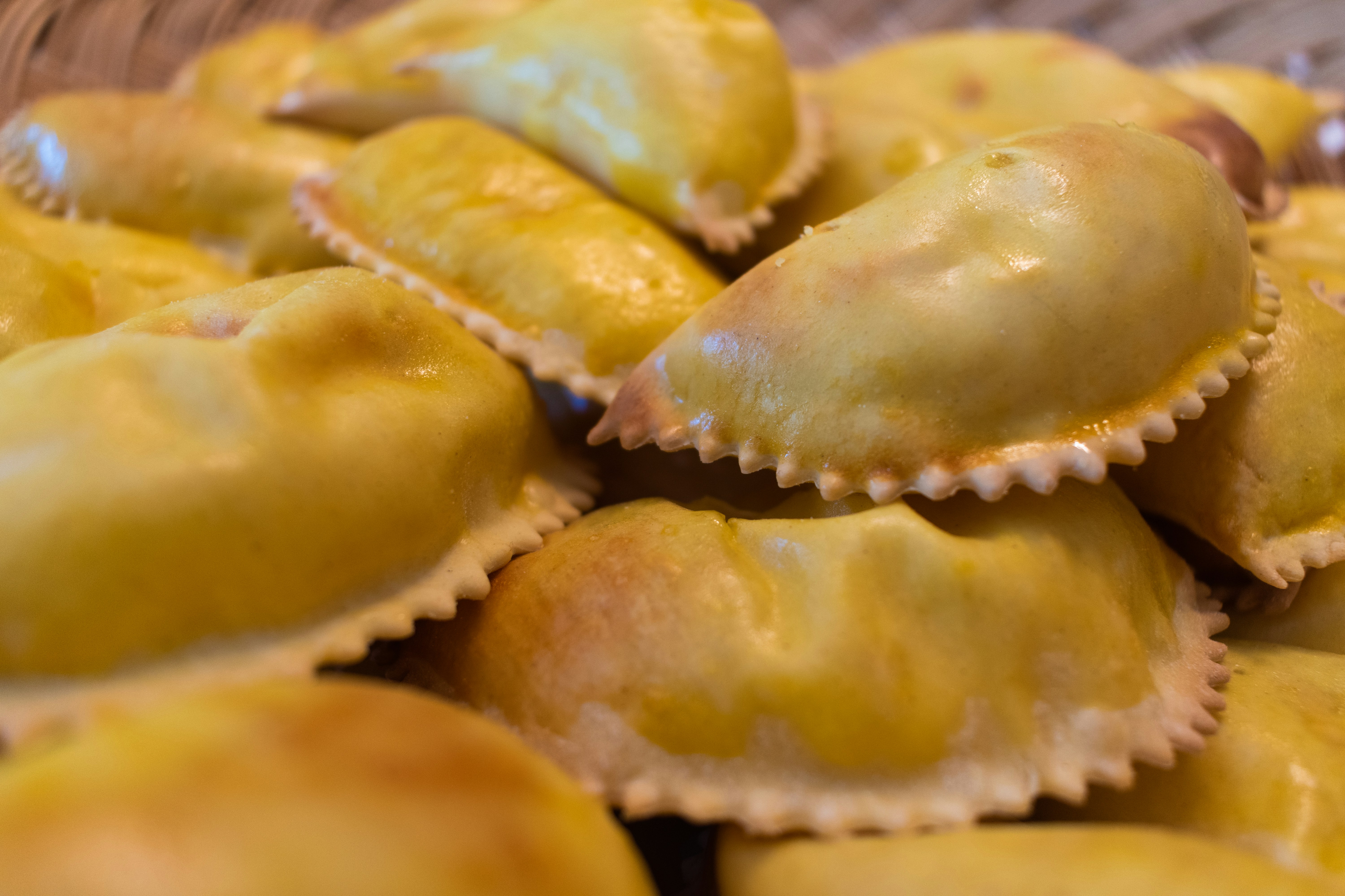 Pile of golden baked pastries with crimped edges