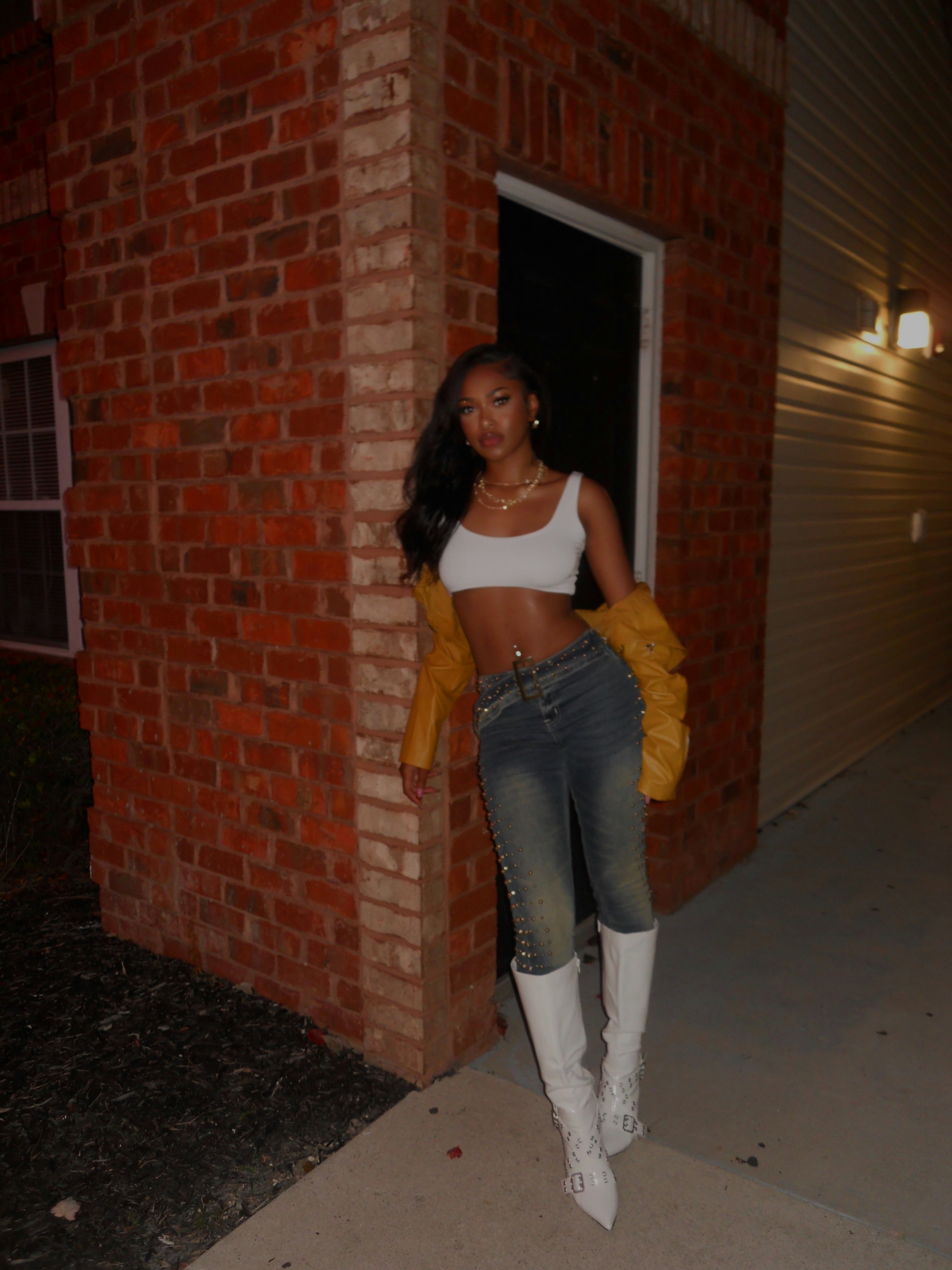 Night pose by brick wall: crop-ready confidence in denim and yellow