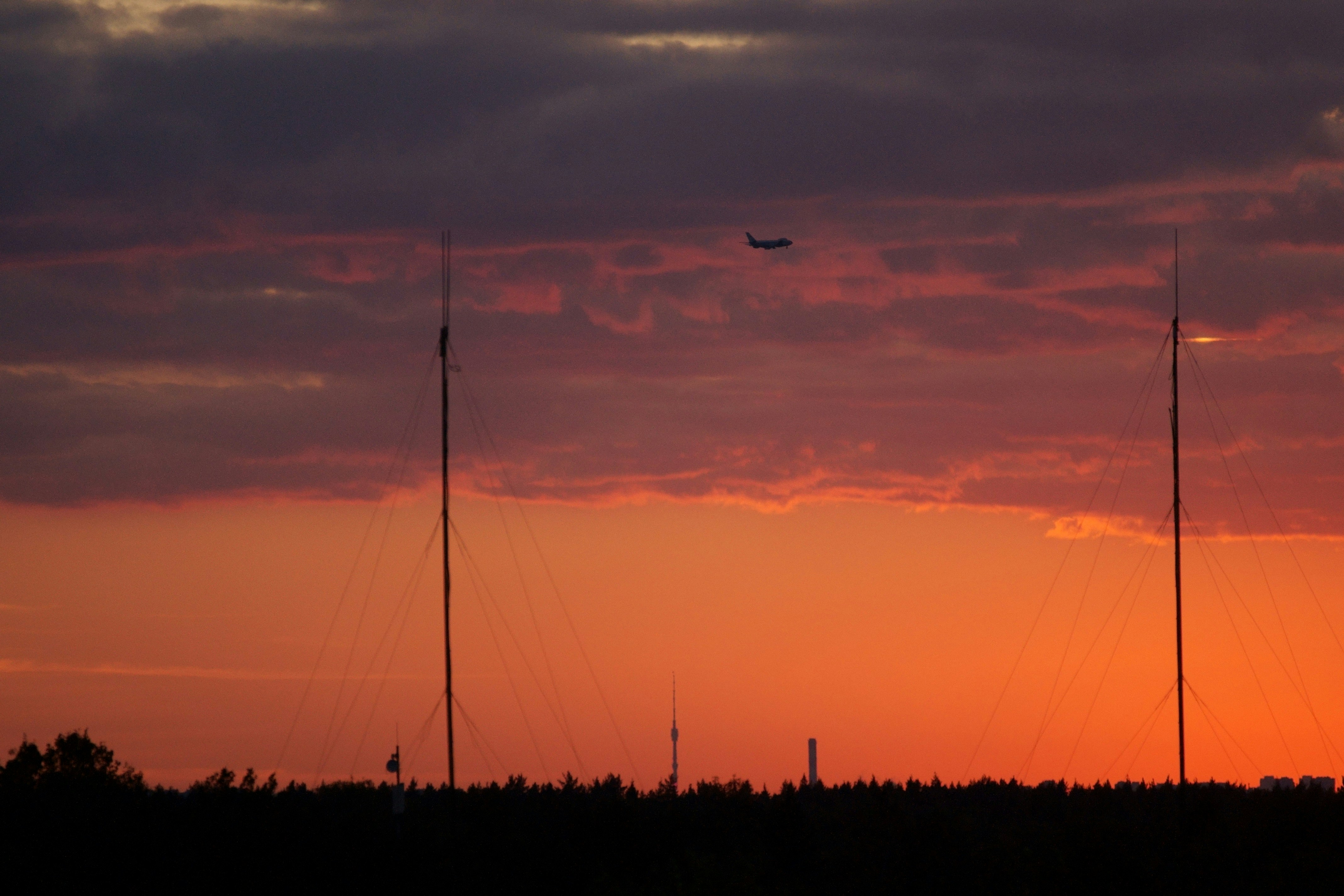 Airplane flying in the sky at sunset.