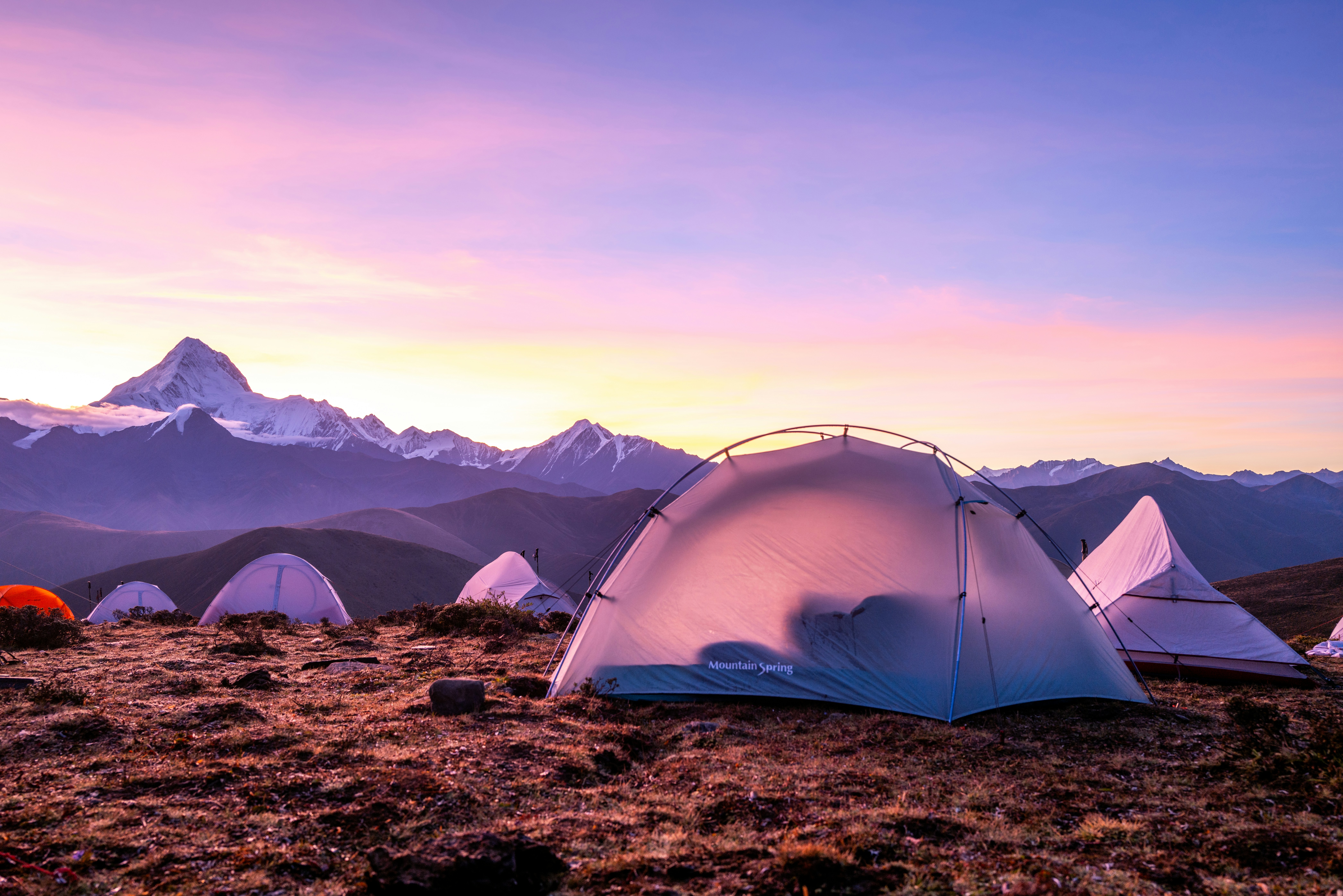 Dawn Over the Alpine Campground: Blue Tents Beneath a Pink Horizon