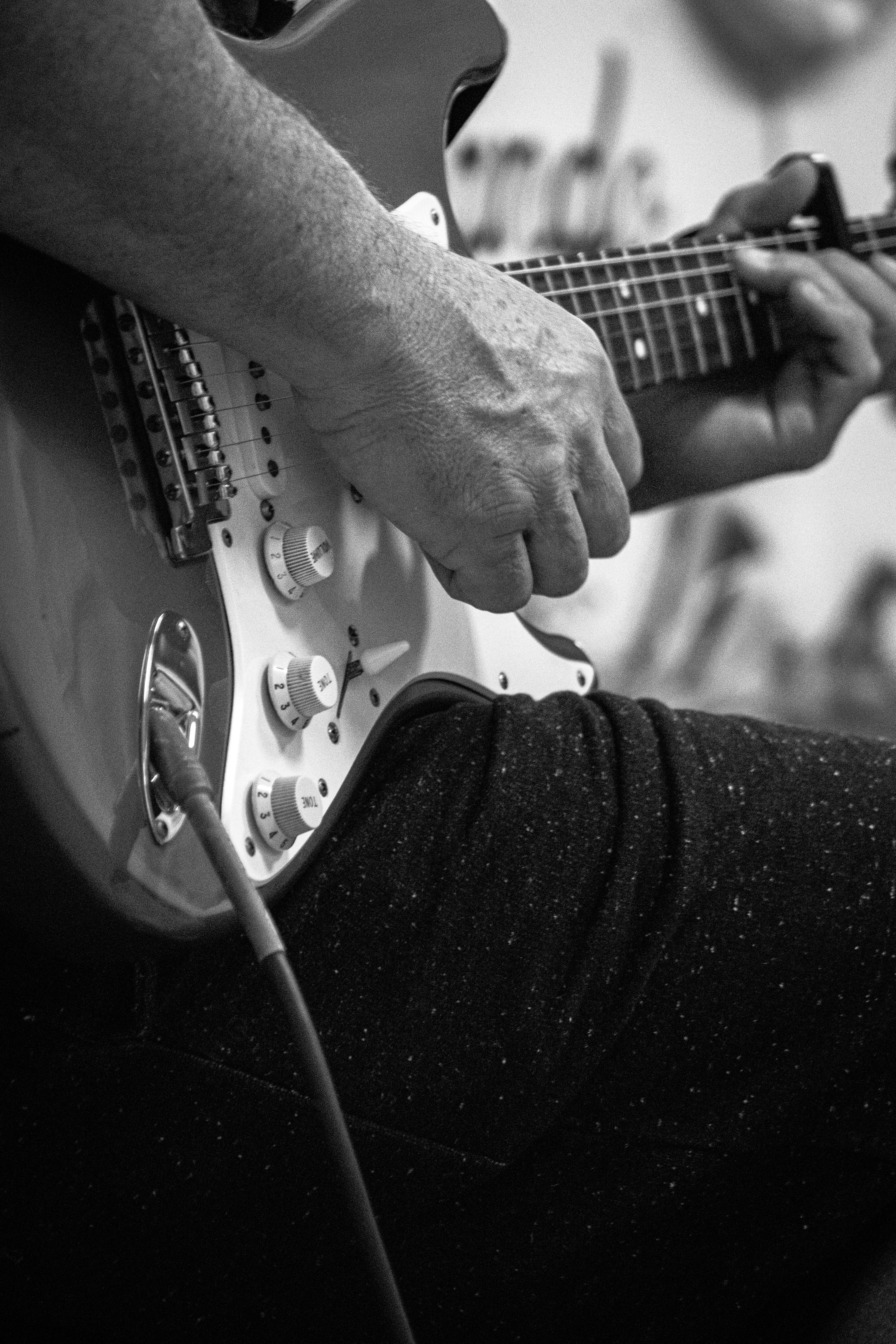 Solo de Guitarra | Musician playing an electric guitar with a cable plugged in.