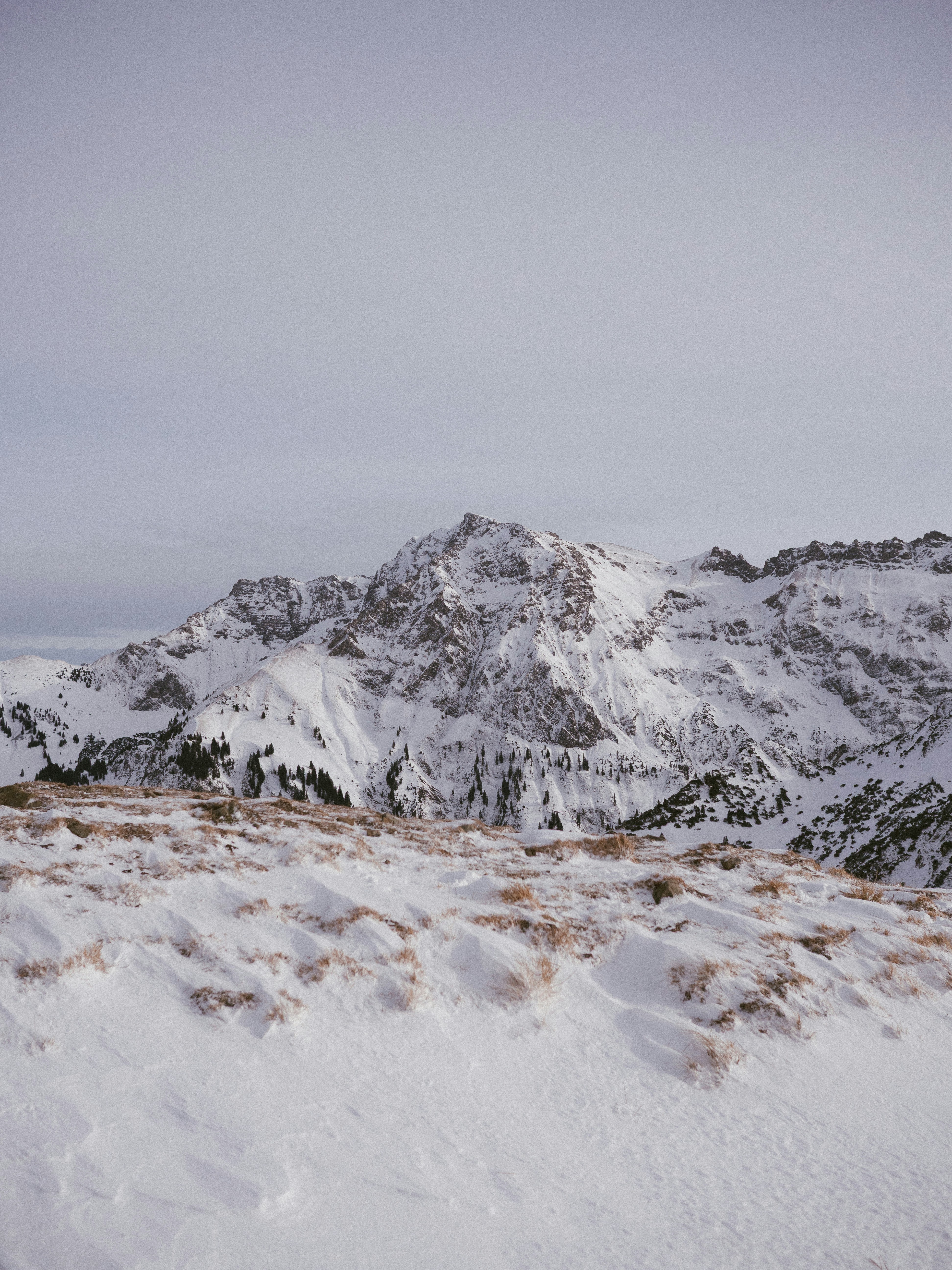 Snow-covered mountains under a cloudy sky.