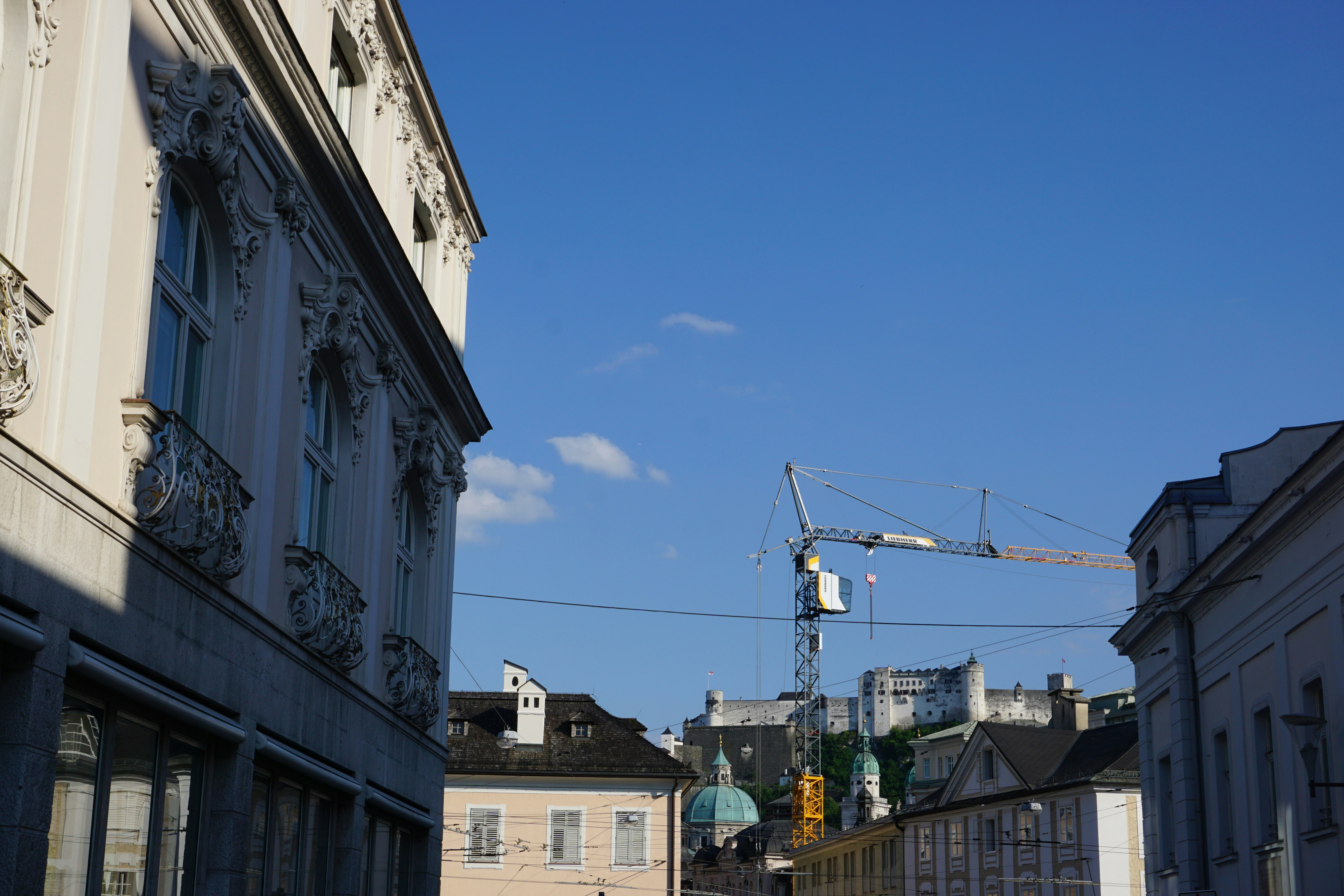 Crane Over the City: Blue Sky Between Ornate Facades