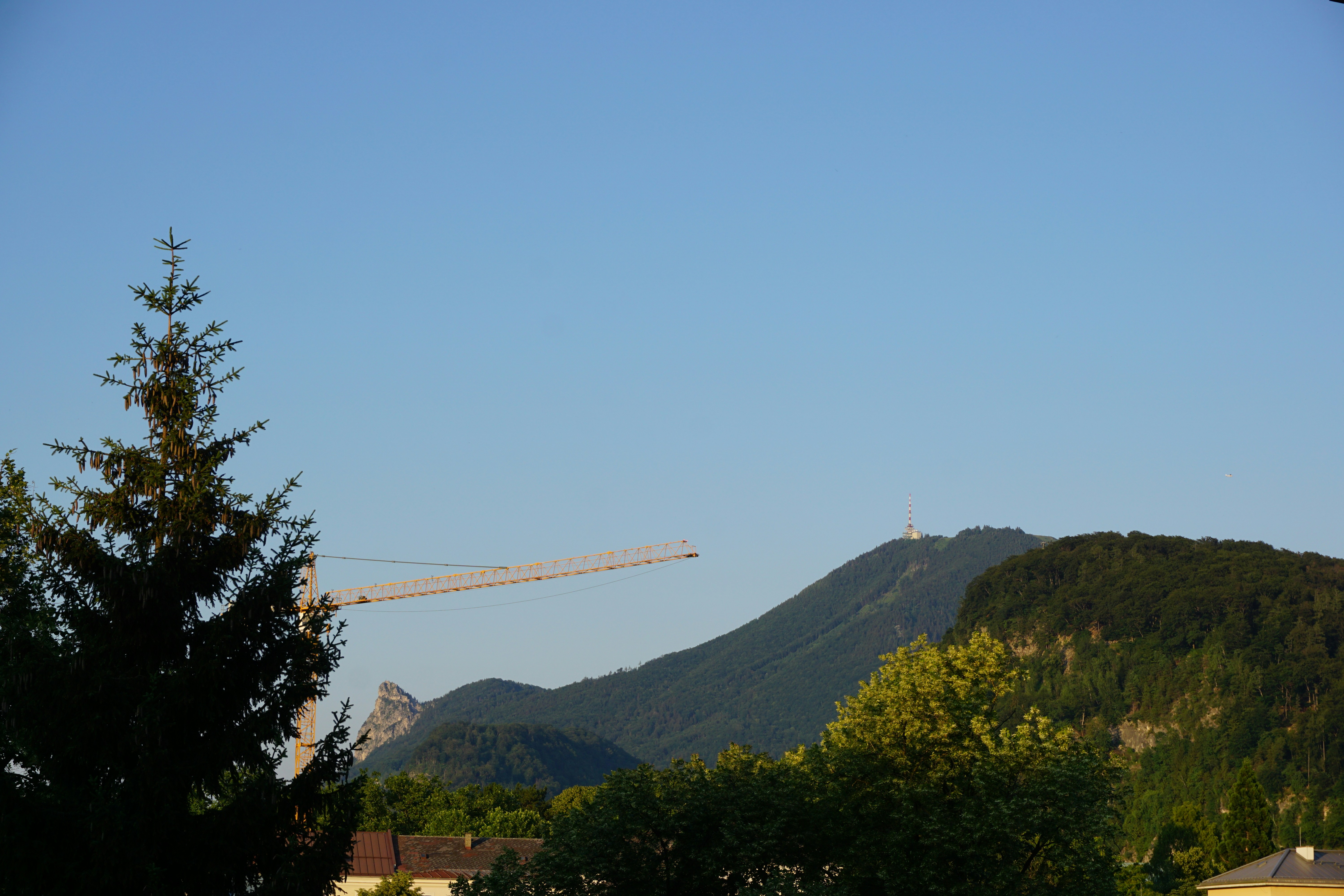 Crane and mountains under a clear blue sky.
