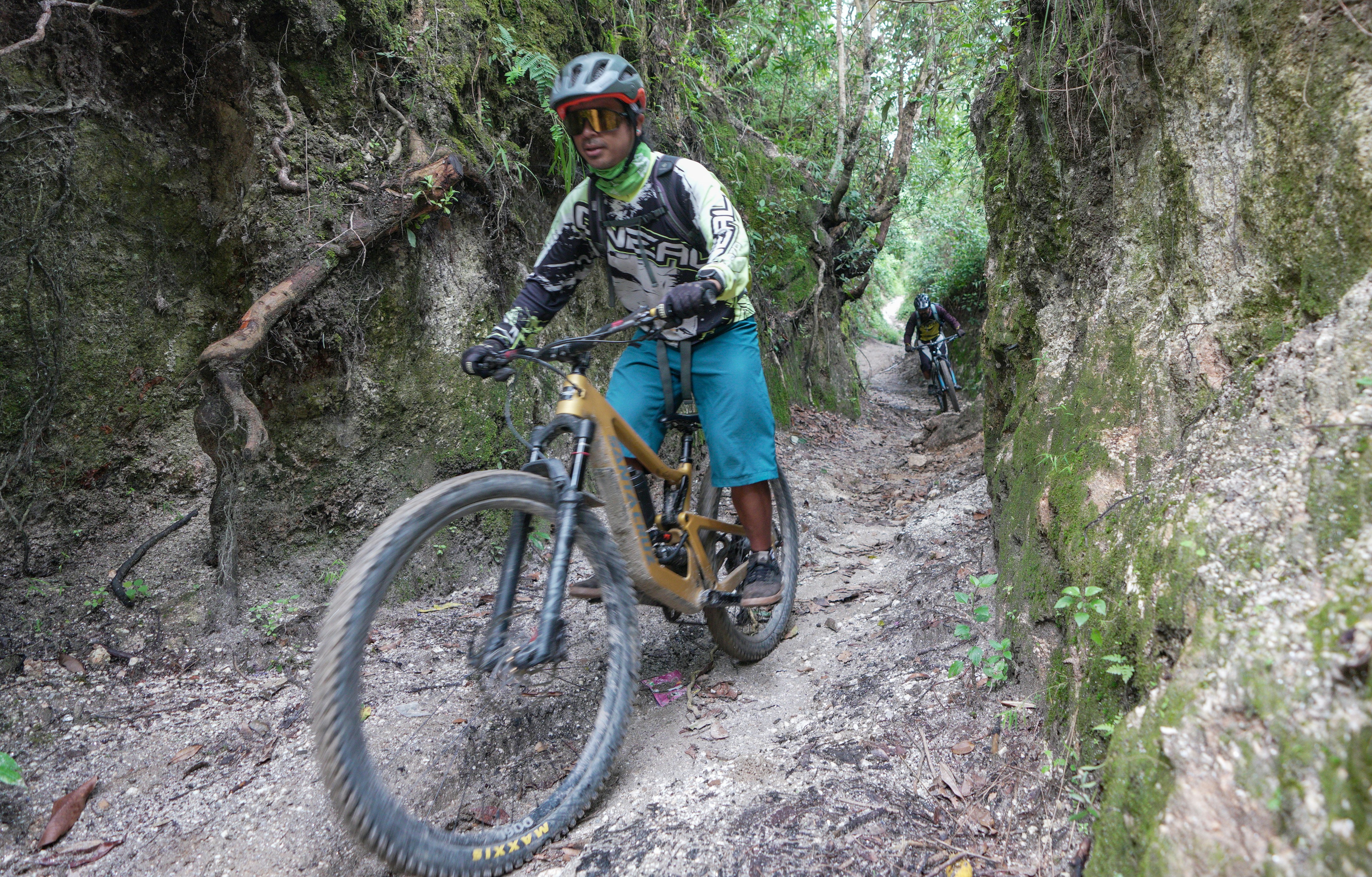 Man rides a mountain bike on a narrow forest trail