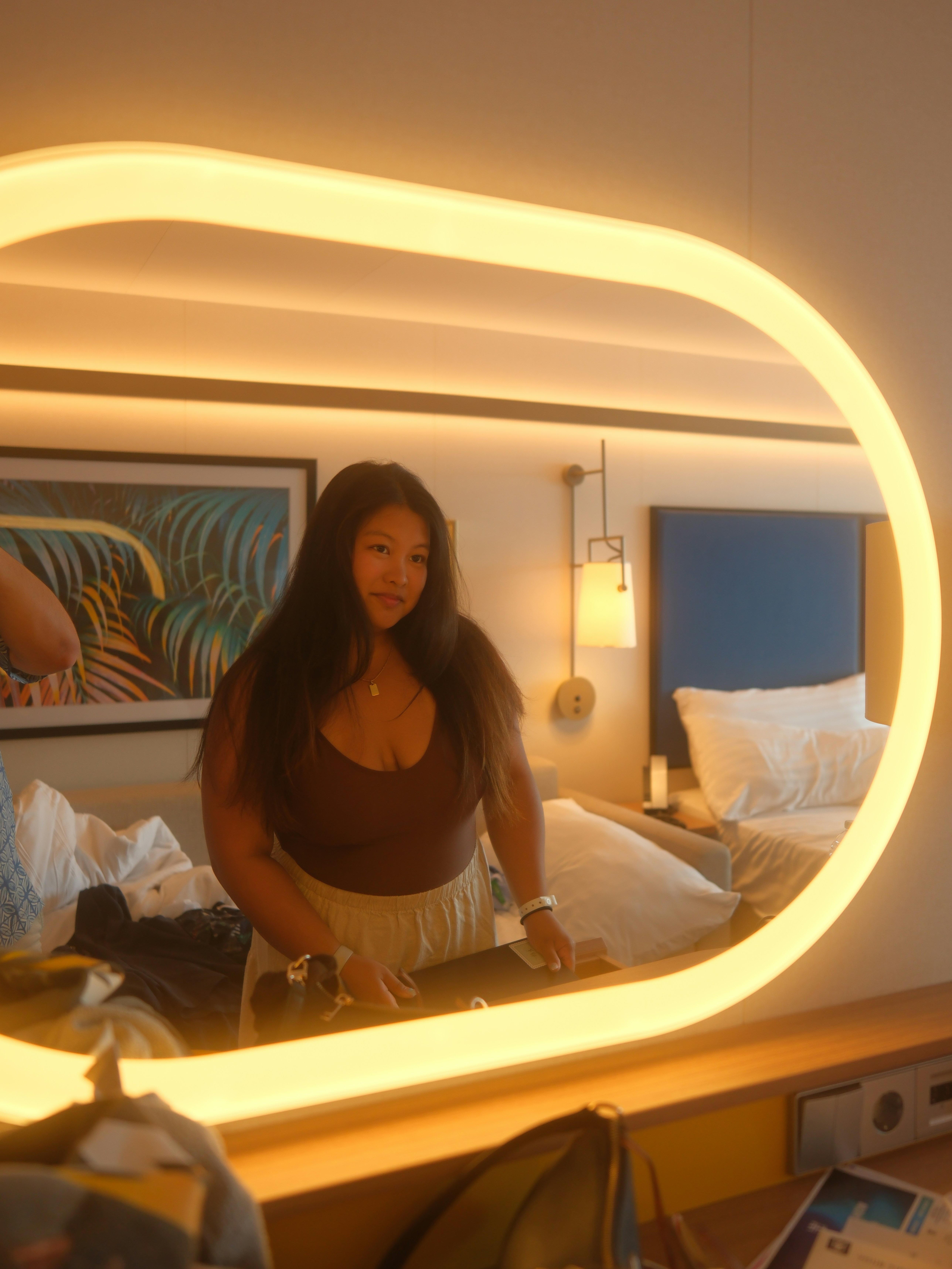 Young woman looking in a brightly lit mirror