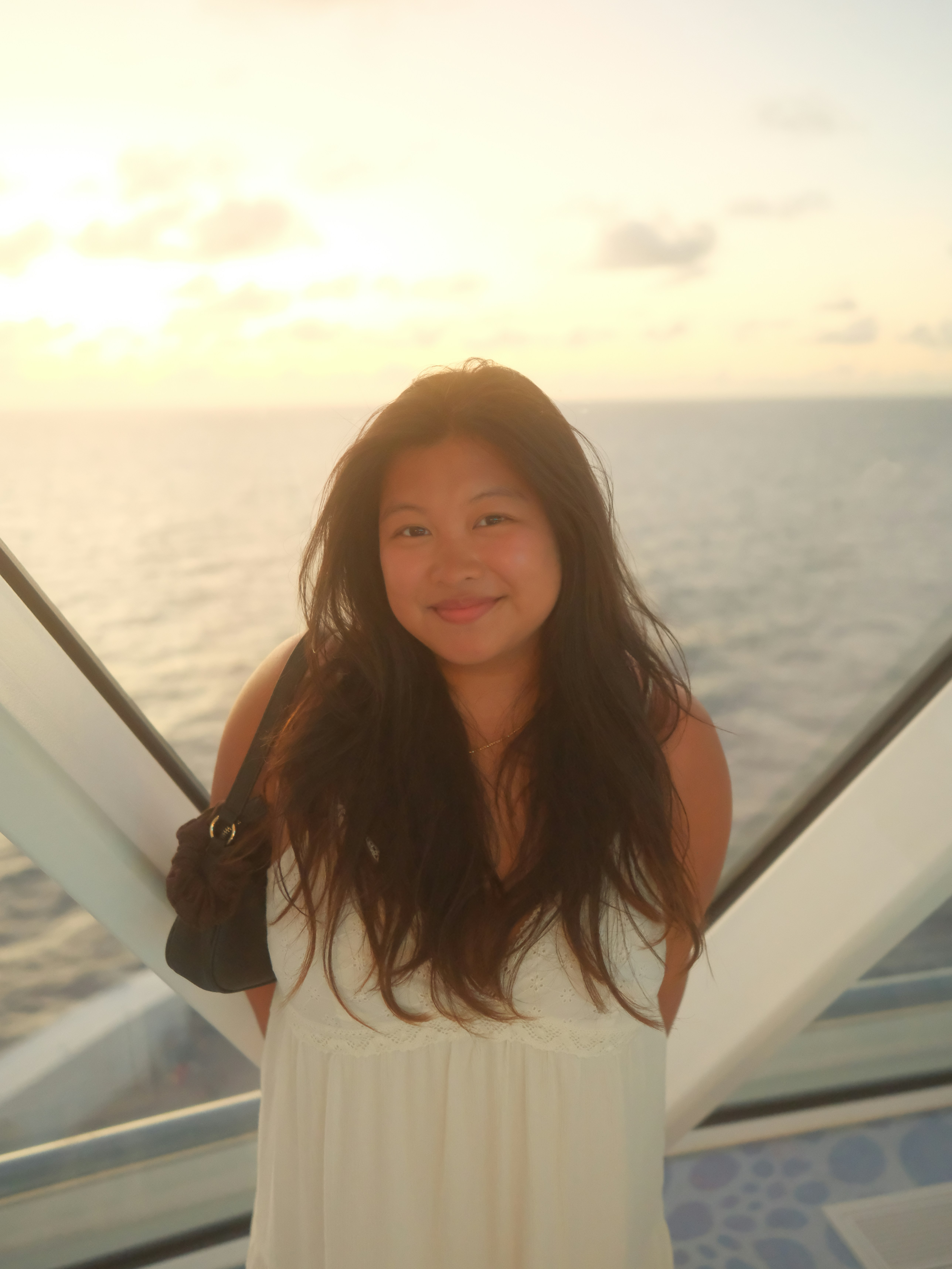 Young woman smiling with ocean sunset behind