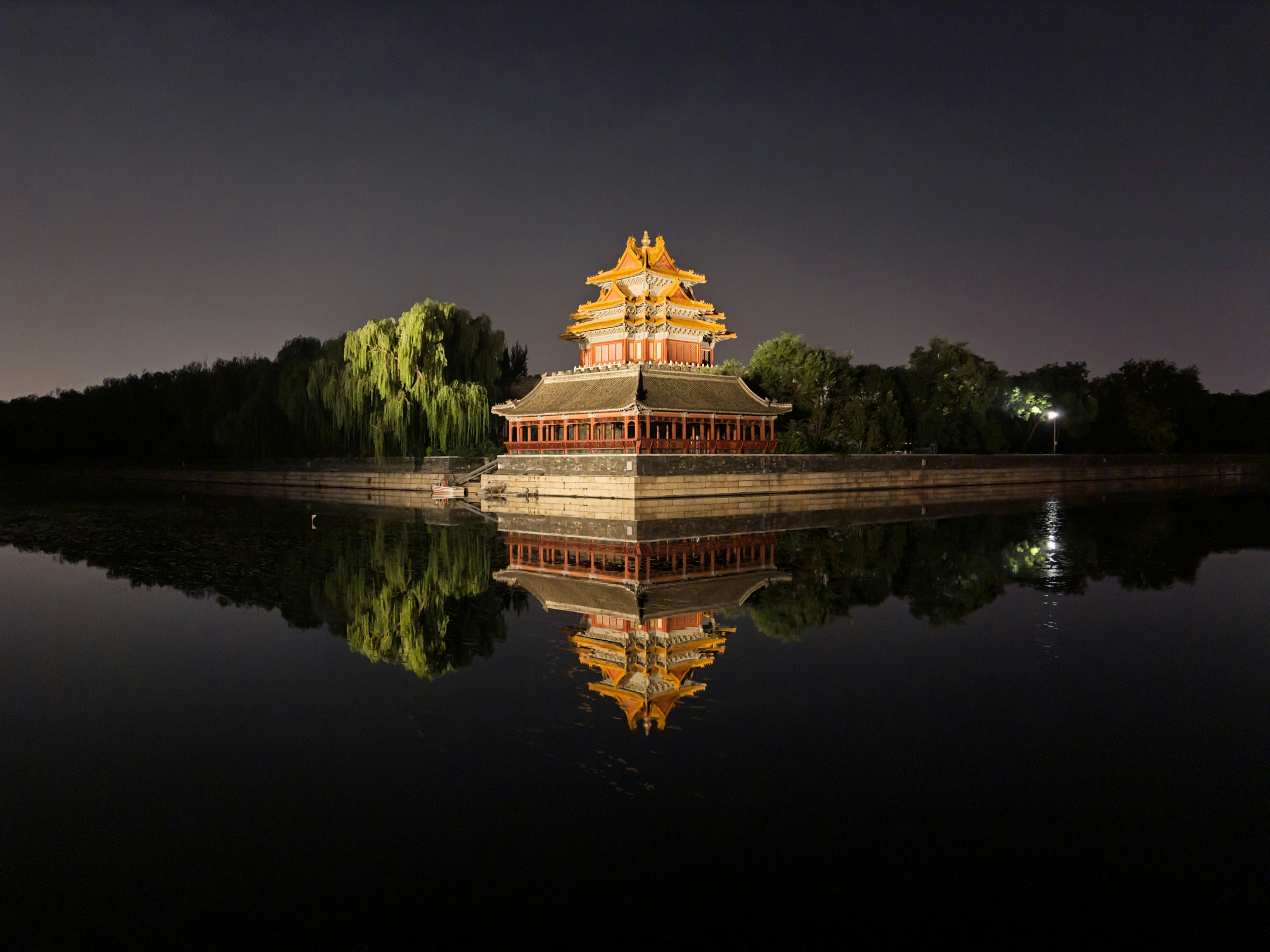 Ornate building reflected in calm water at night