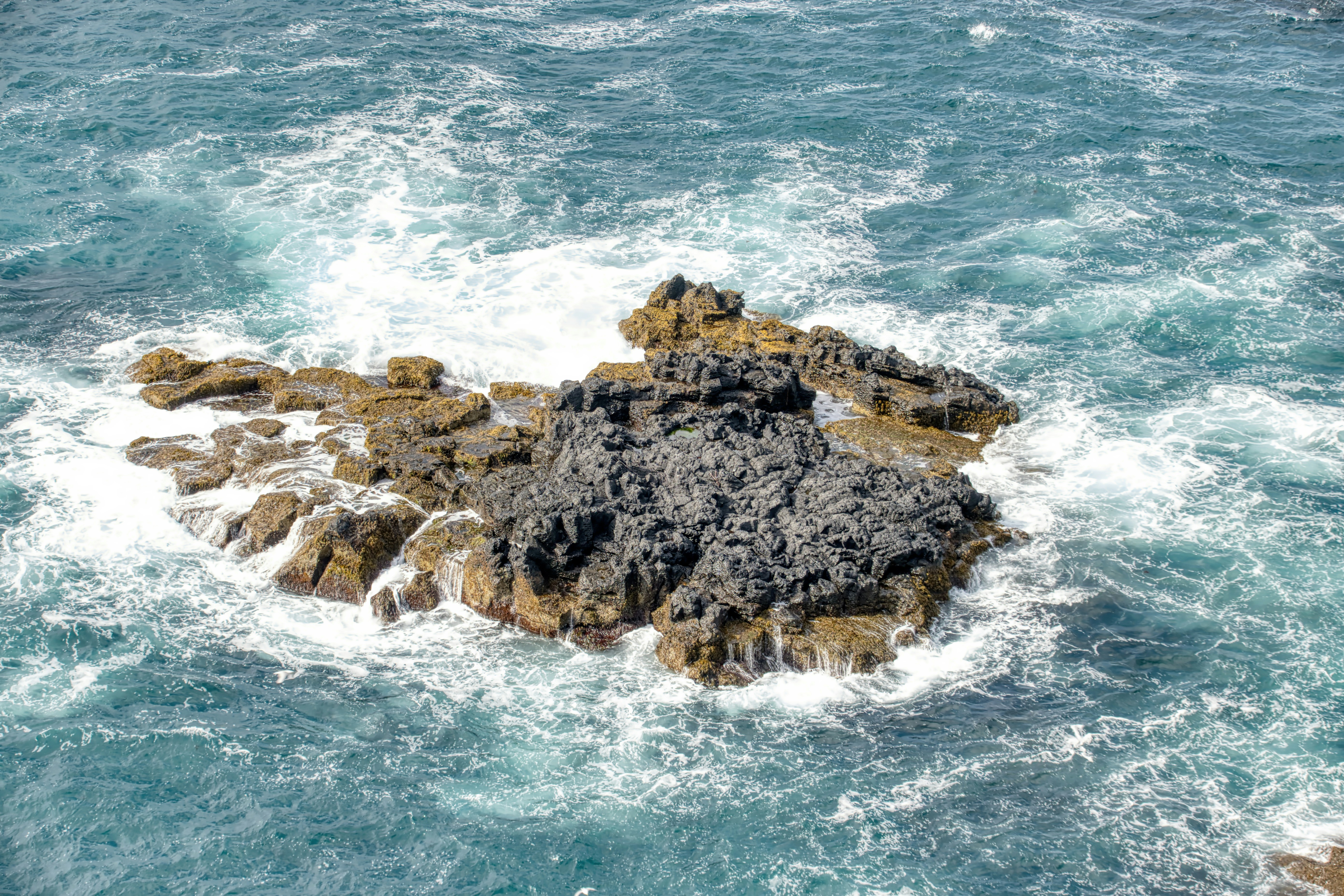 Isolated Rocky Outcrop Amidst Turbulent Waters