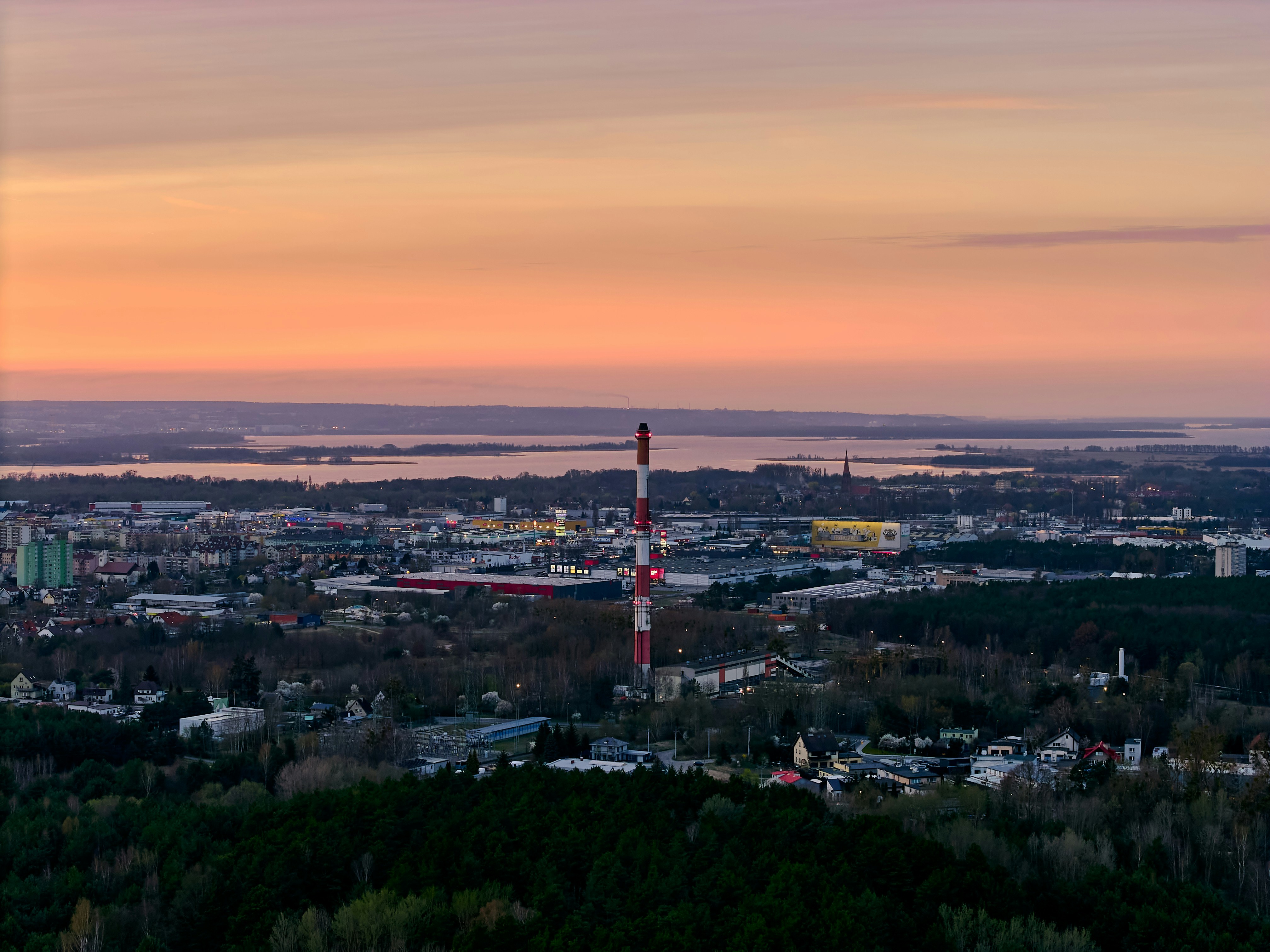 Cityscape with a tall striped tower at sunset