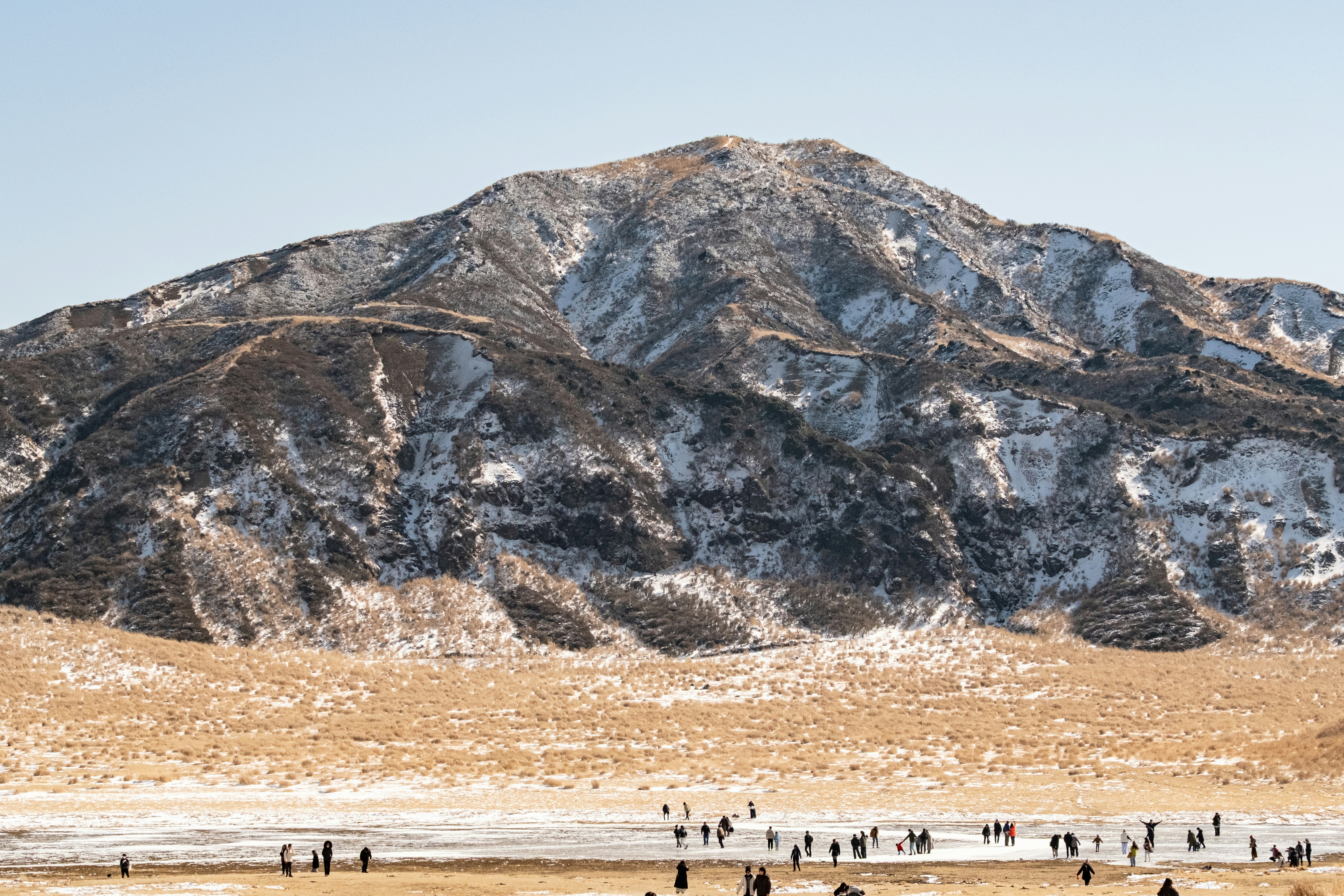 Snow-dusted mountain landscape with people below
