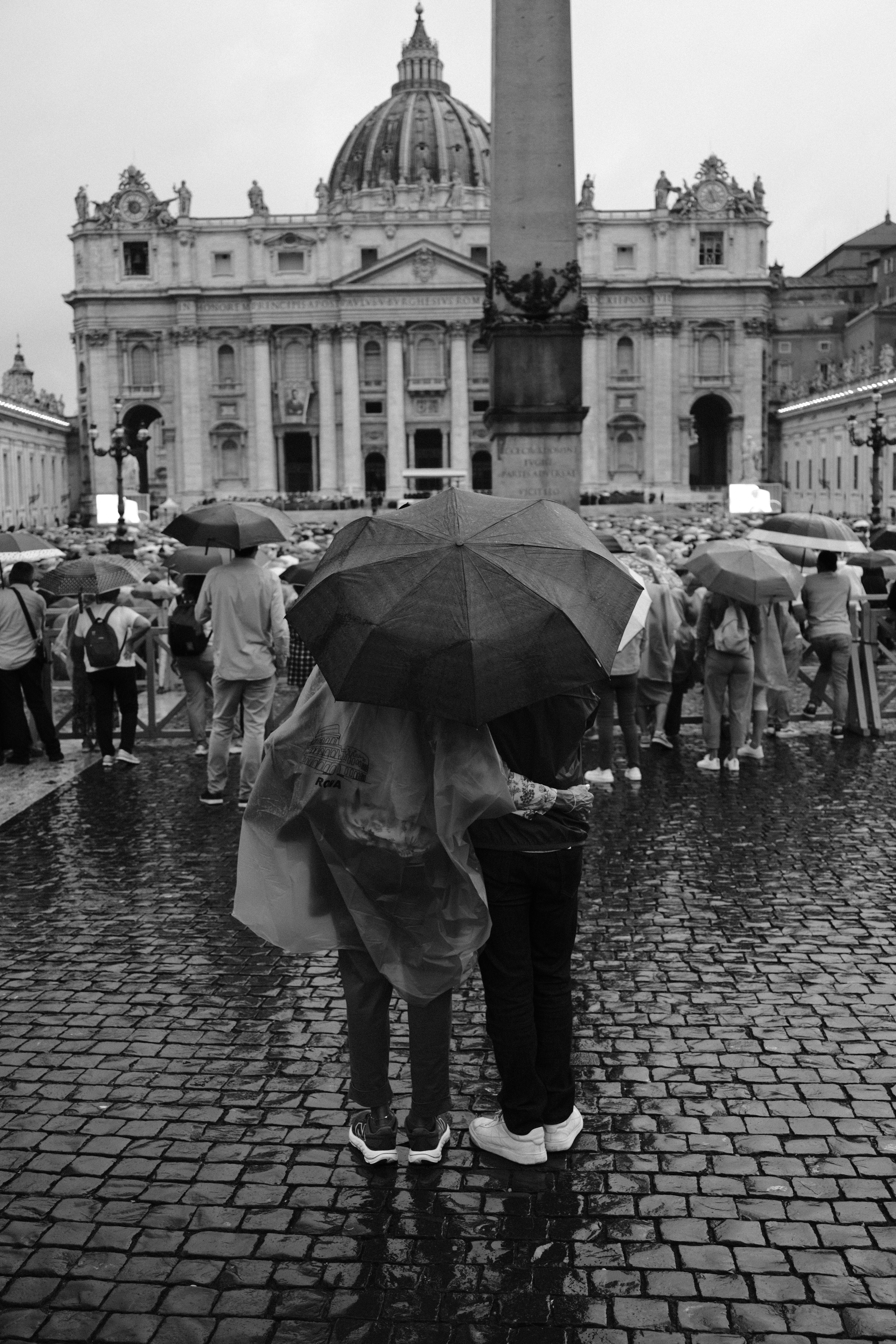 amor real | Couple under umbrella in front of st. peter's basilica