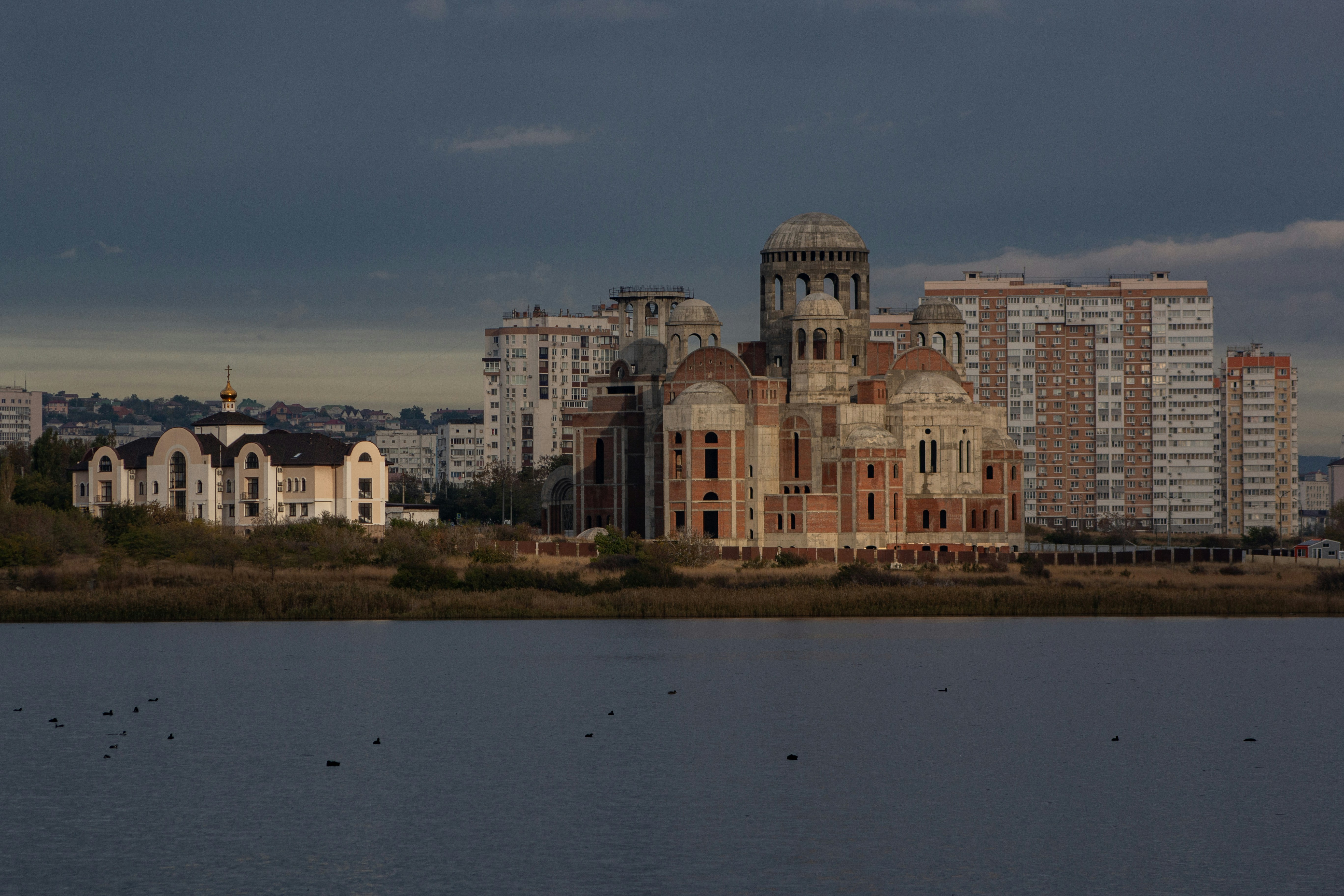 Ornate building with modern structures by water